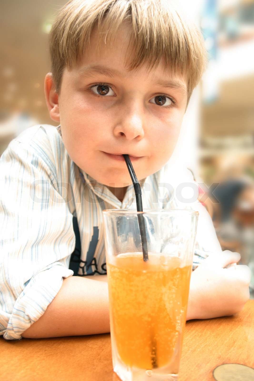 A child boy sipping softdrink thorough a straw at the shopping mall ...