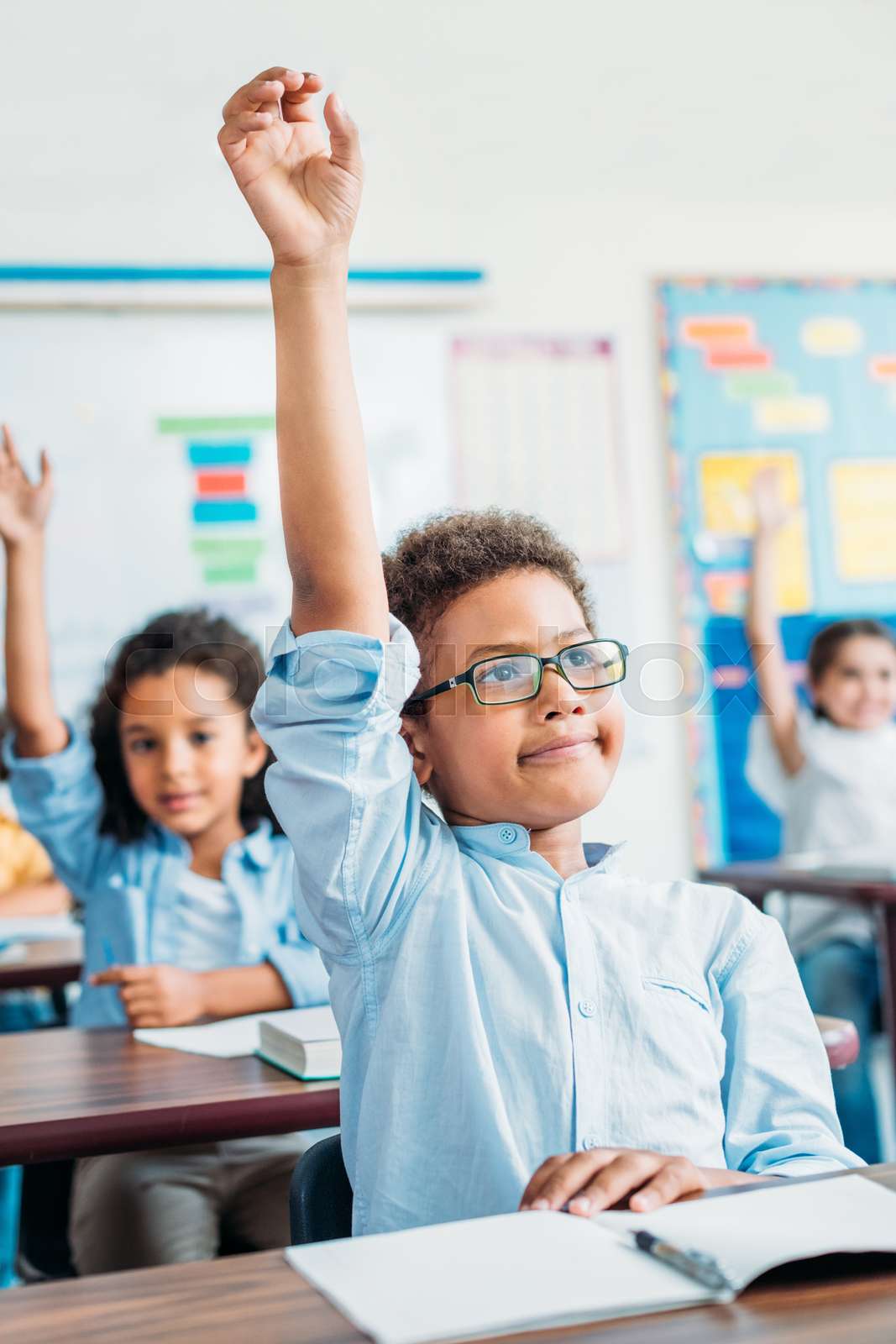 kids raising hands in class | Stock image | Colourbox