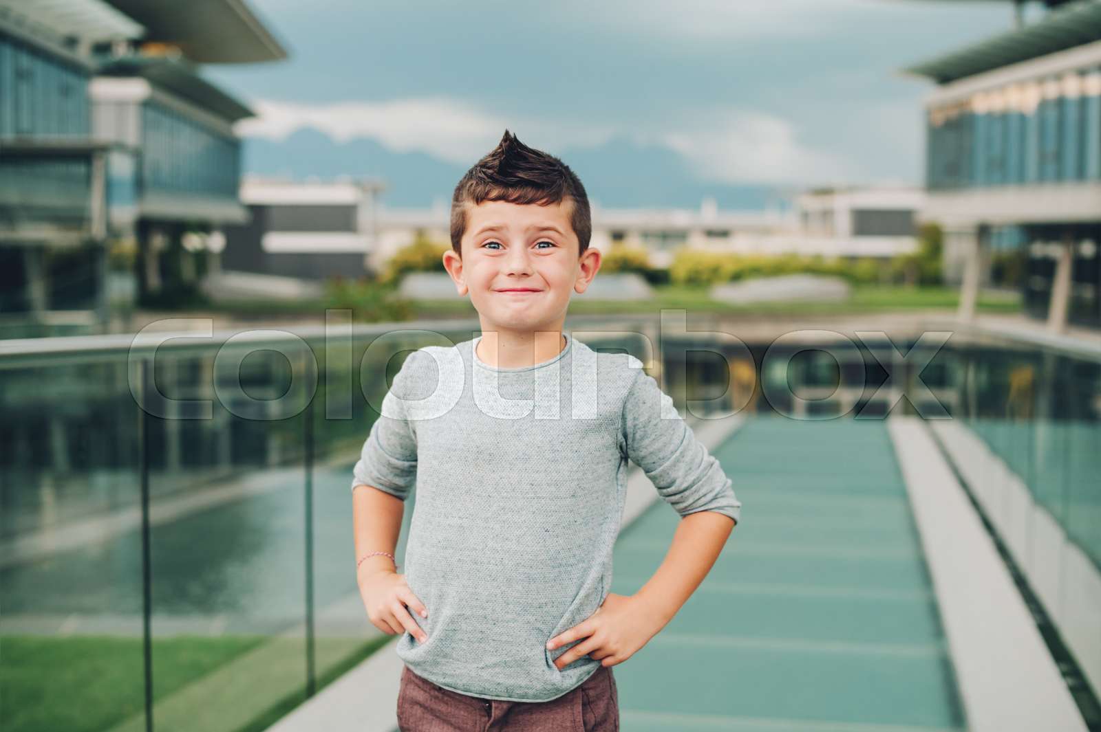 Outdoor portrait of cute little 6 year old boy wearing blue pullover ...