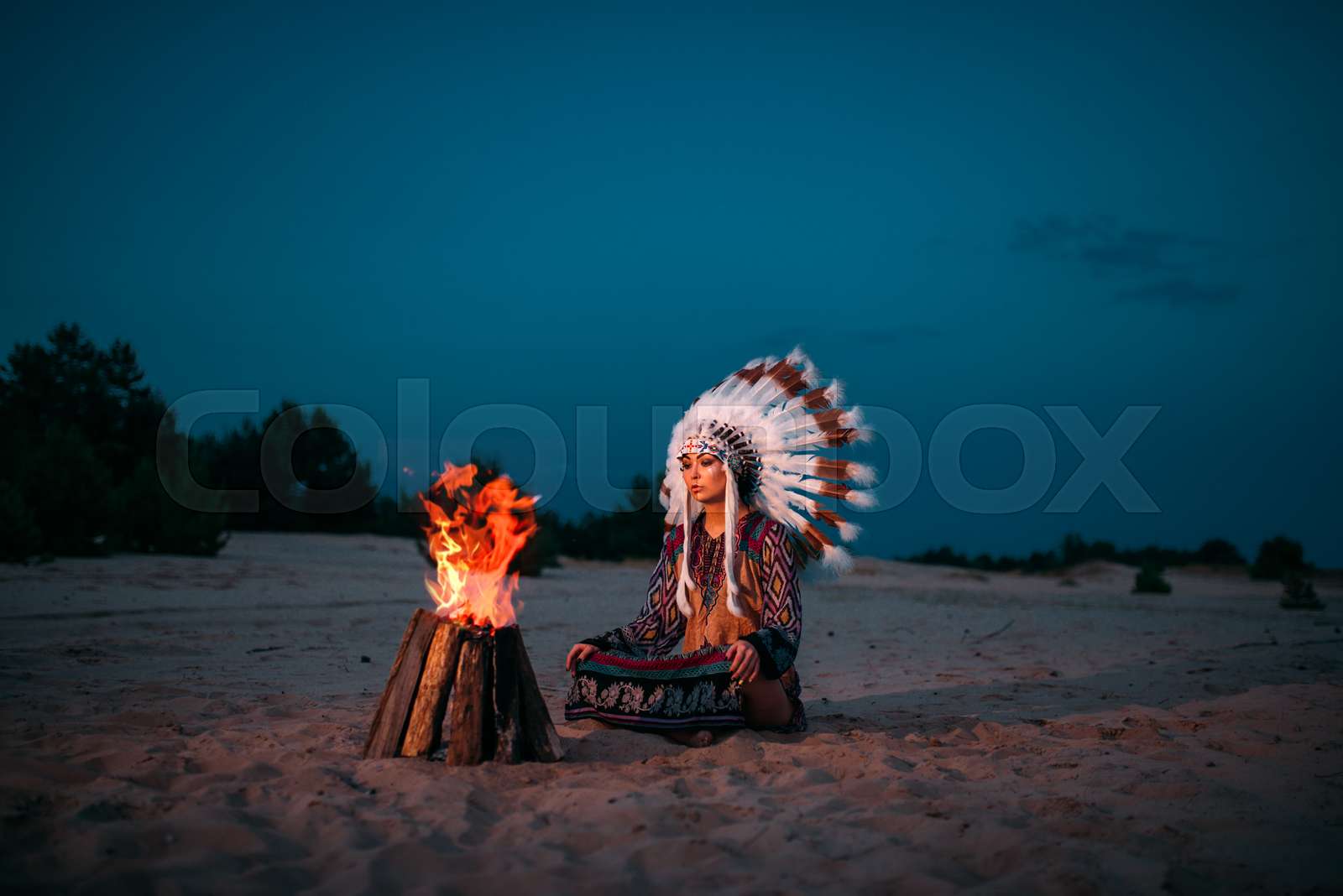 Young American Indian woman against fire | Stock image | Colourbox