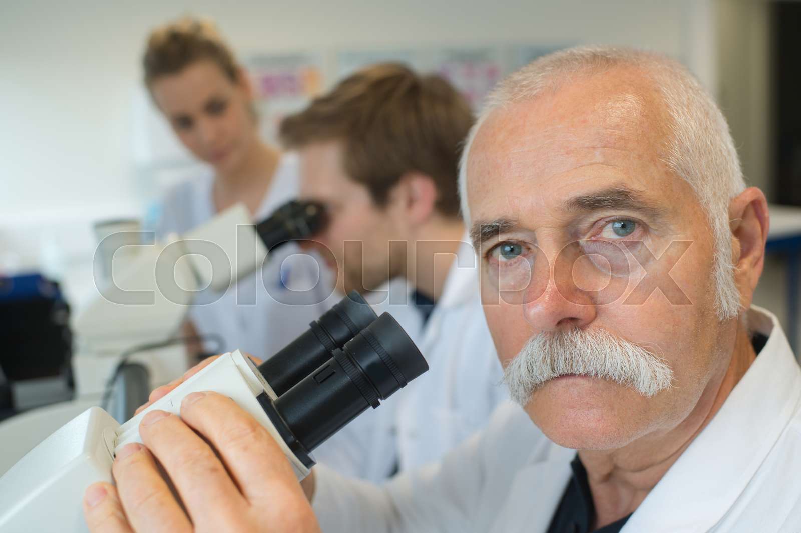 senior head scientist microscoping in the life science research ...