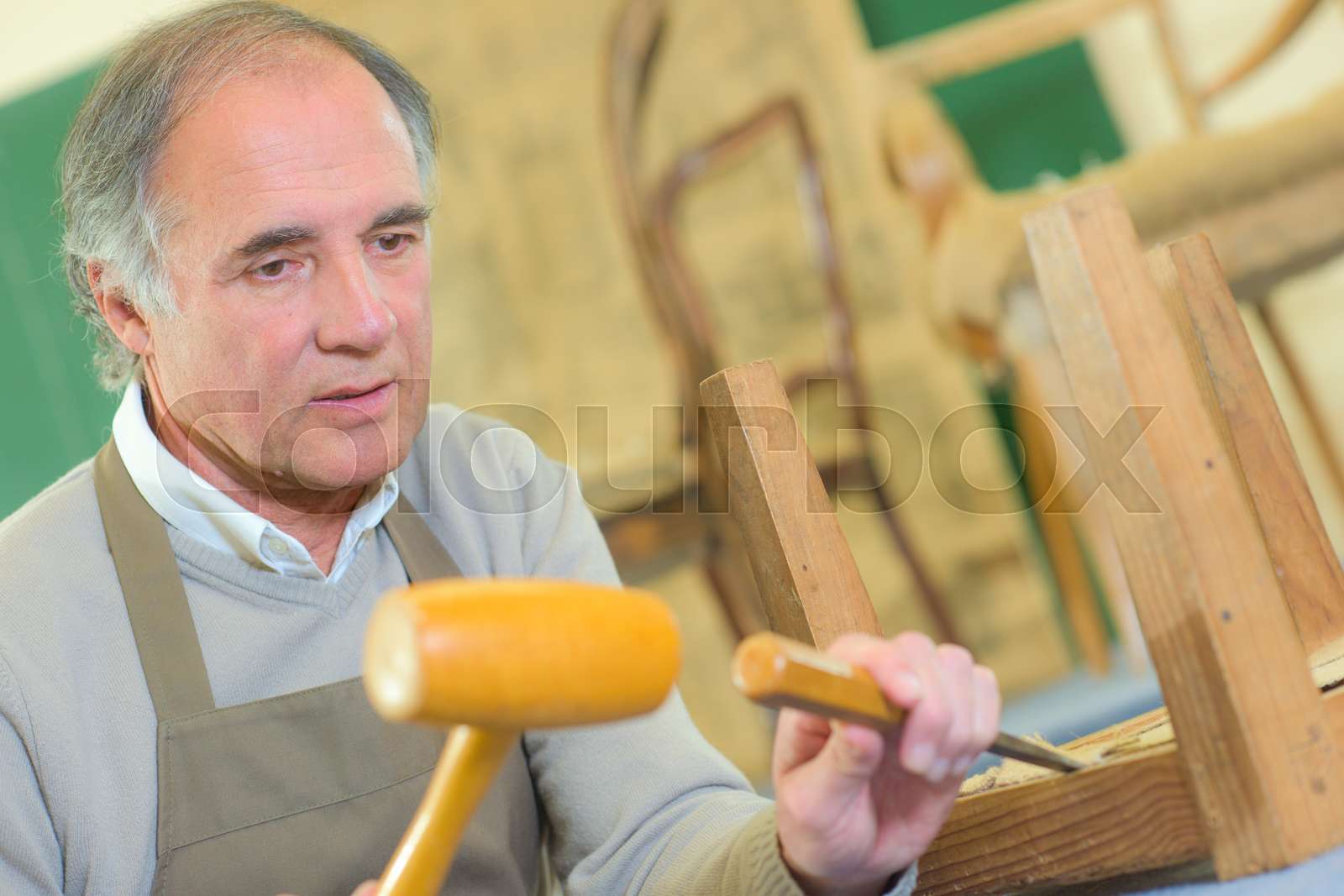 Carpenter Working At A Wood Table With Hammer And Chisel Stock Image carpenter-working-at-a-wood-table-with-hammer-and-chisel-stock-image