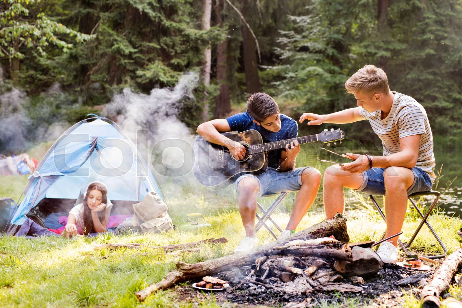 Teenagers camping in forest. Summer adventure. | Stock image | Colourbox