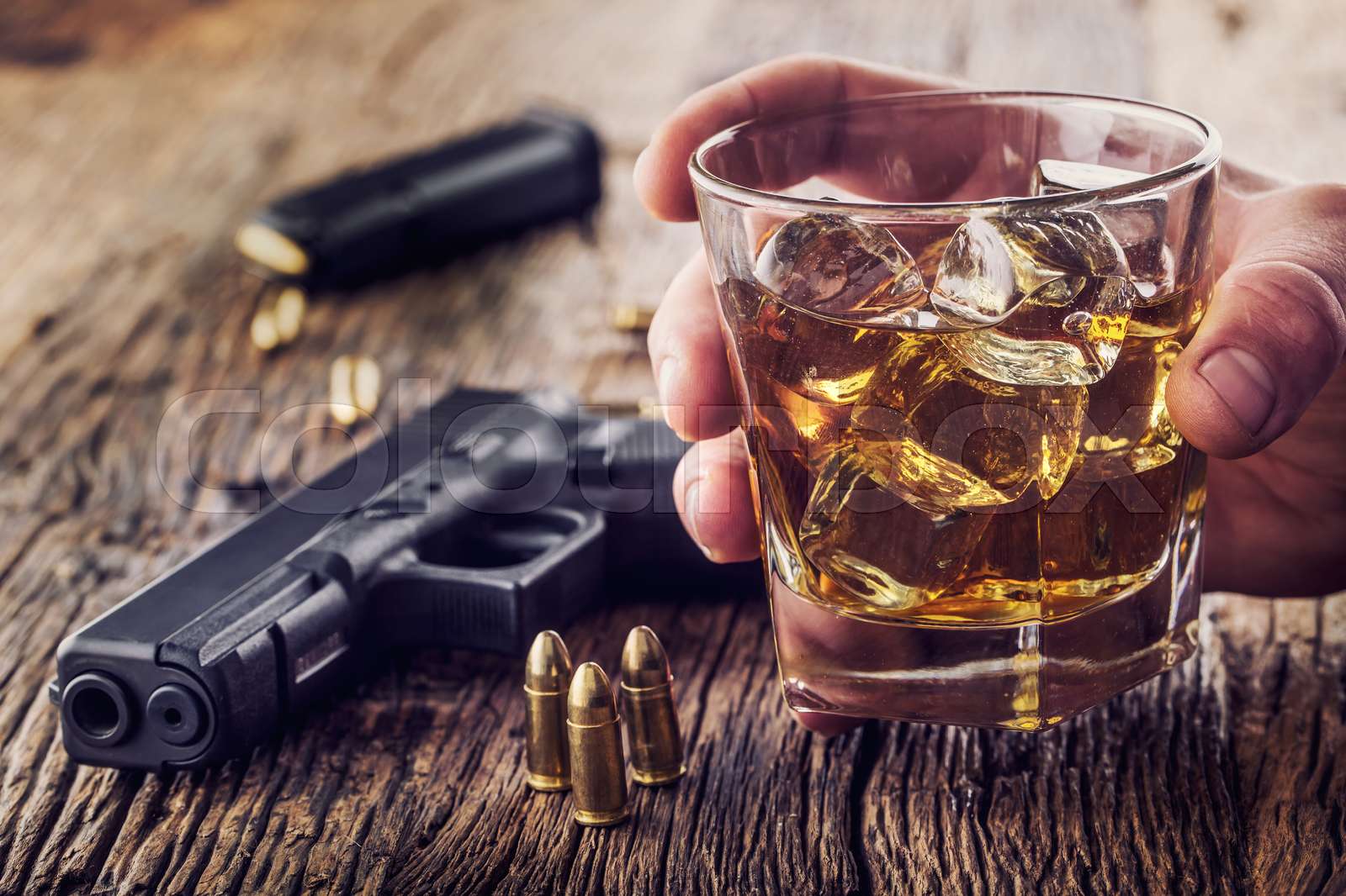 Gun and alcohol. 9mm pistol gun and cup whiskey cognac or brandy ...