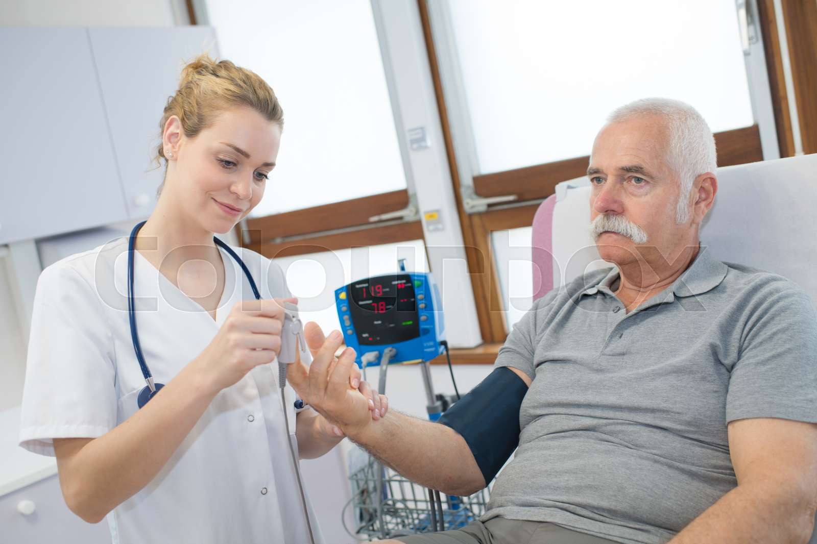 female doctor showing putting a finger prick device on patient | Stock ...