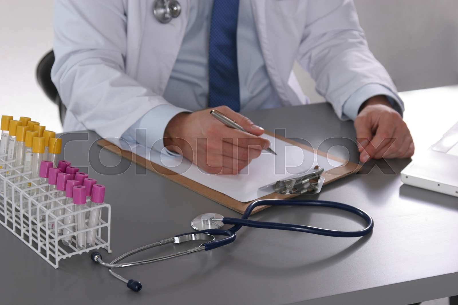 Male doctor write on the desk with test tube | Stock image | Colourbox