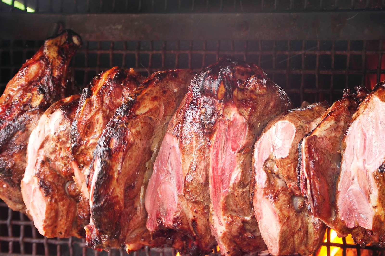 roast meat by fire with flames, traditionally eaten at different family ...