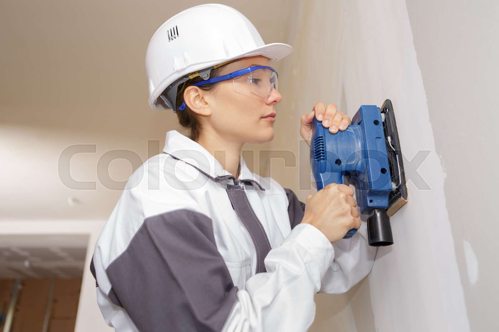 woman plasterer polishing the wall | Stock image | Colourbox