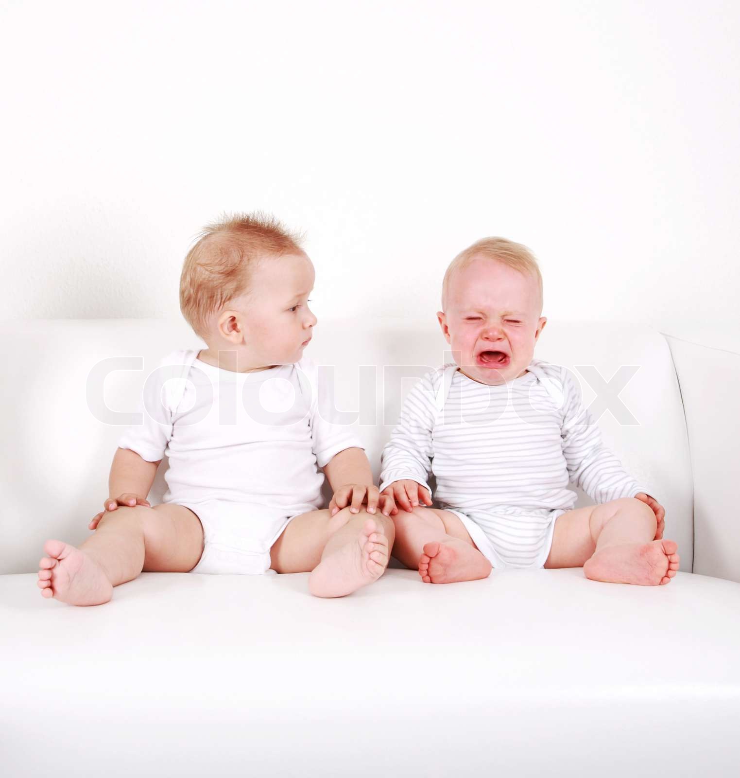 Two sweet babies - one looking, one crying | Stock image | Colourbox