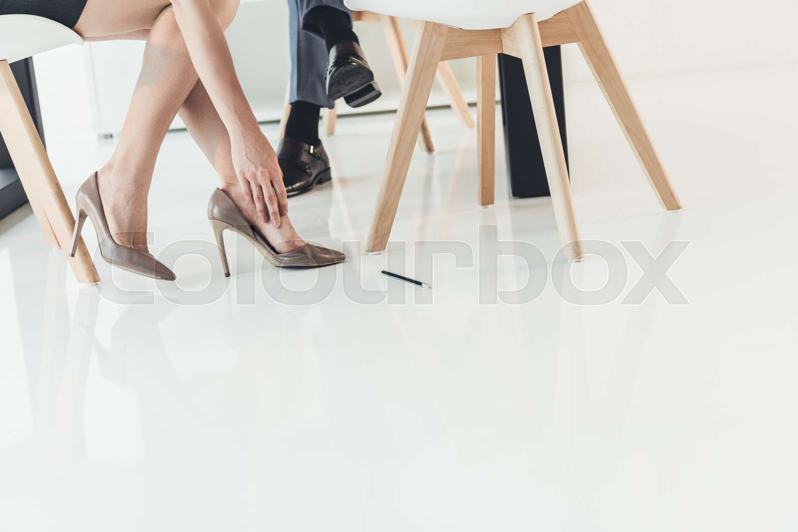 Woman picking up pencil | Stock image | Colourbox