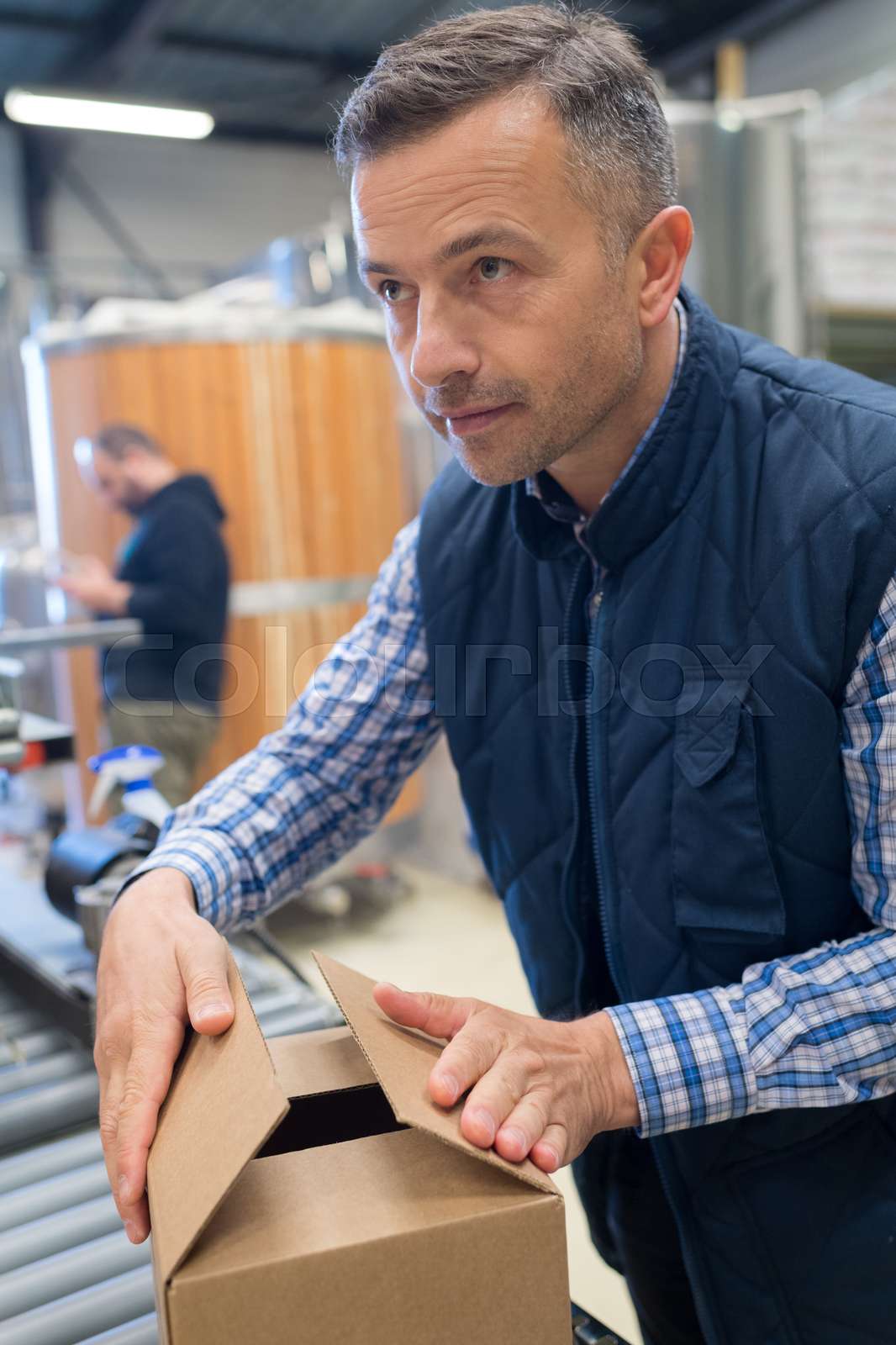 hands of warehouse worker lifting box horizontal | Stock image | Colourbox