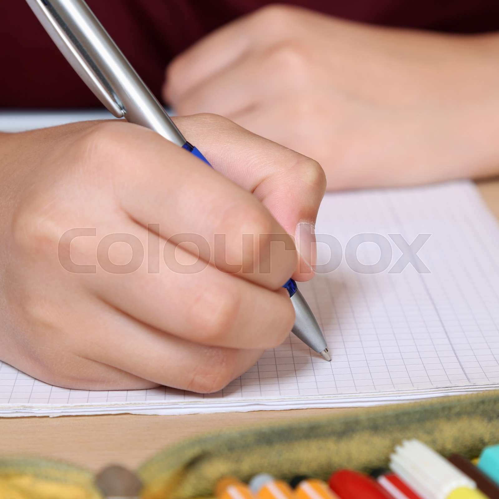 Student writing with hand in his exercise book at school | Stock image ...