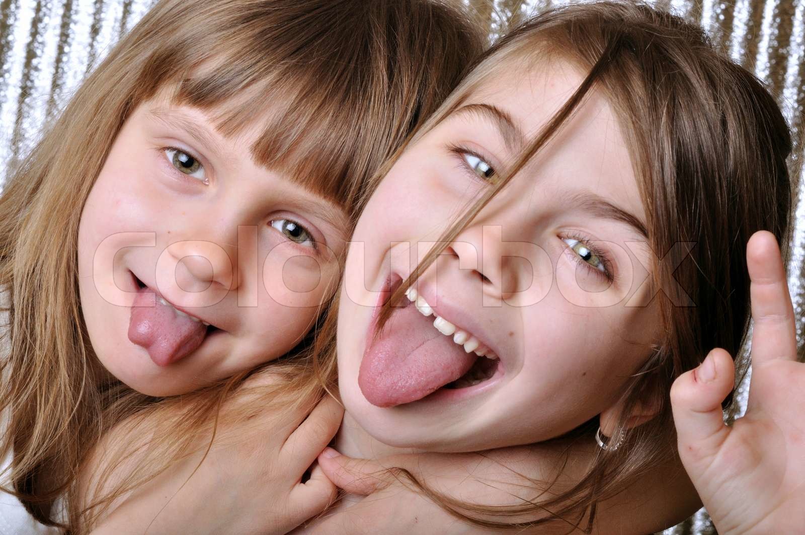 two playful girls with thier tongues out | Stock image | Colourbox