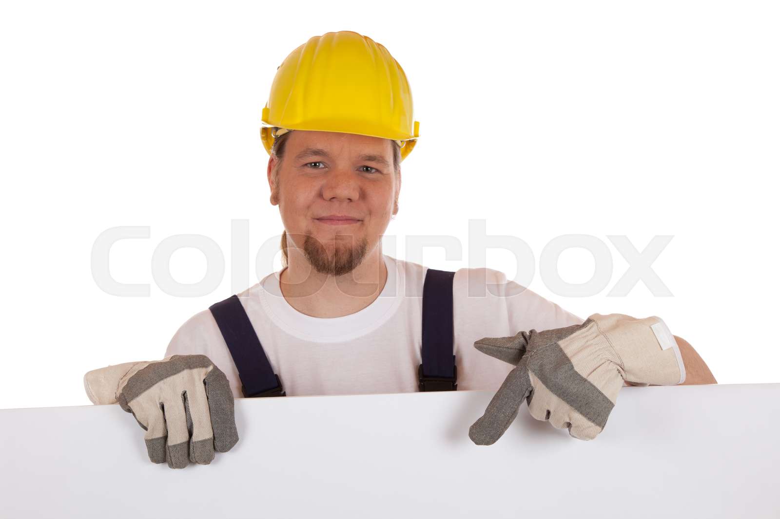 Construction worker showing on a blank sign | Stock image | Colourbox