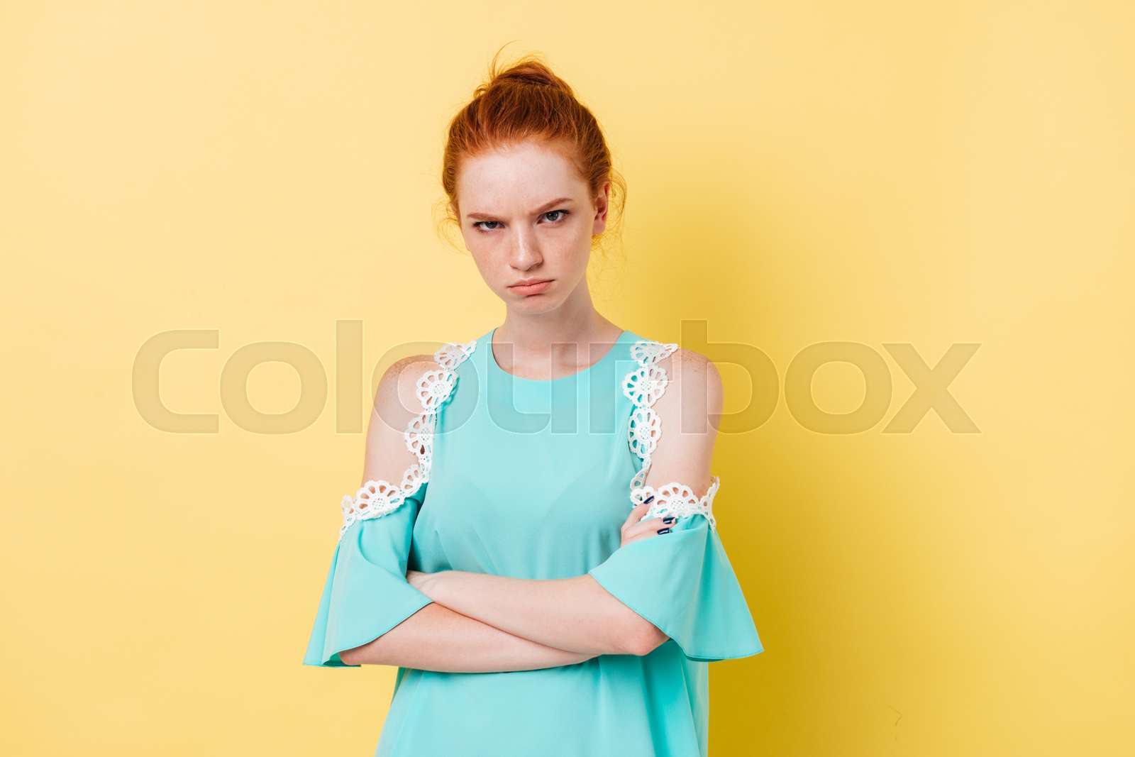 Angry ginger woman in dress holding crossed arms | Stock image | Colourbox