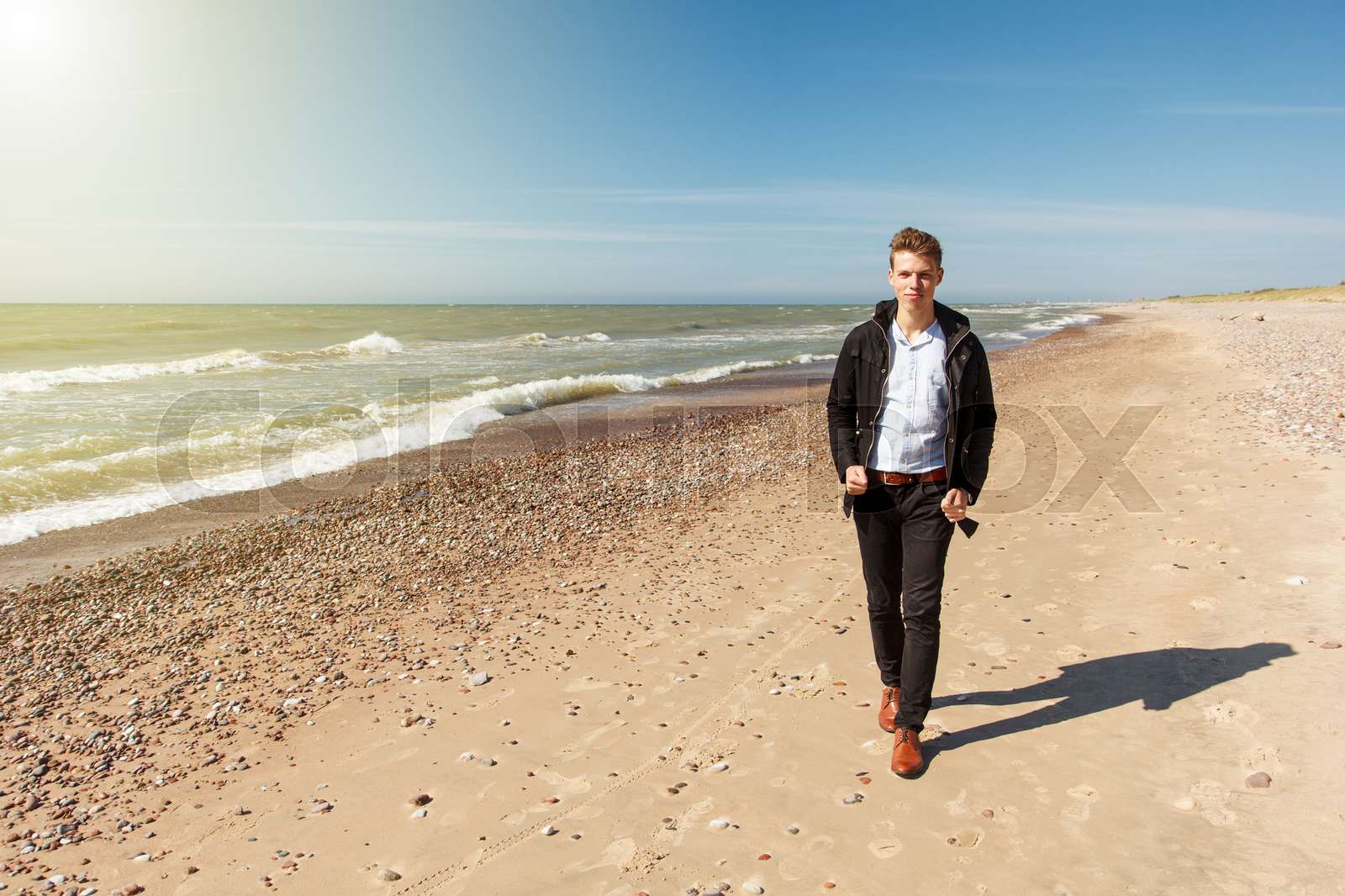 one man walking along an empty beach | Stock image | Colourbox