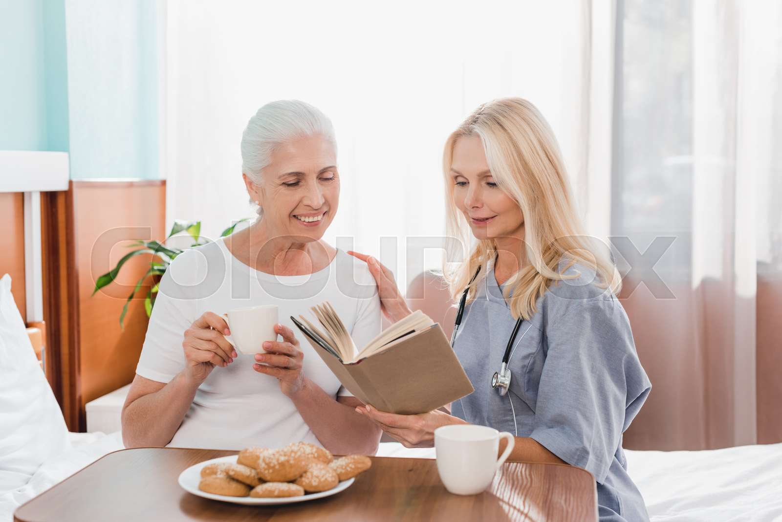 nurse and patient reading book | Stock image | Colourbox