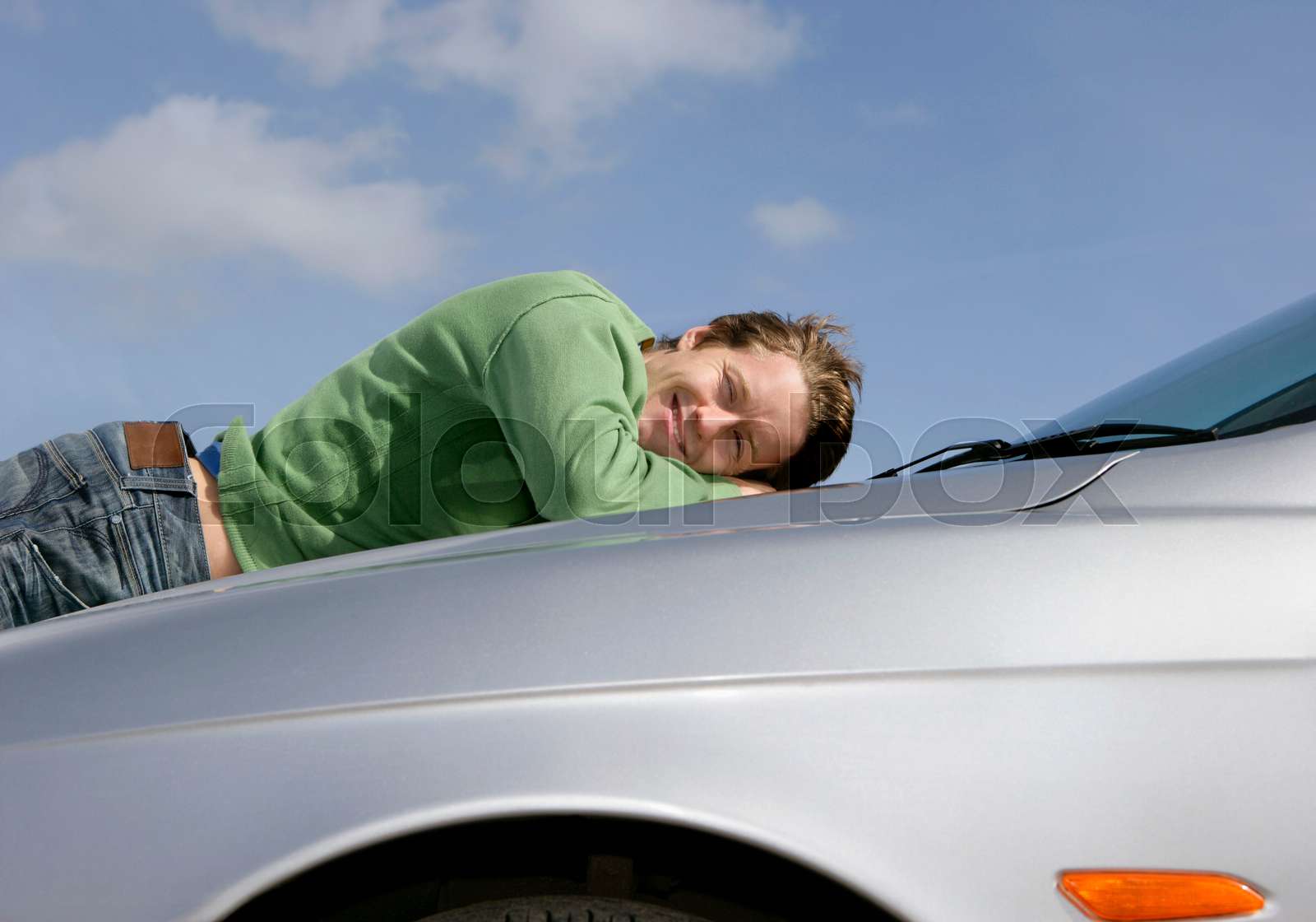 Man lying on car | Stock image | Colourbox