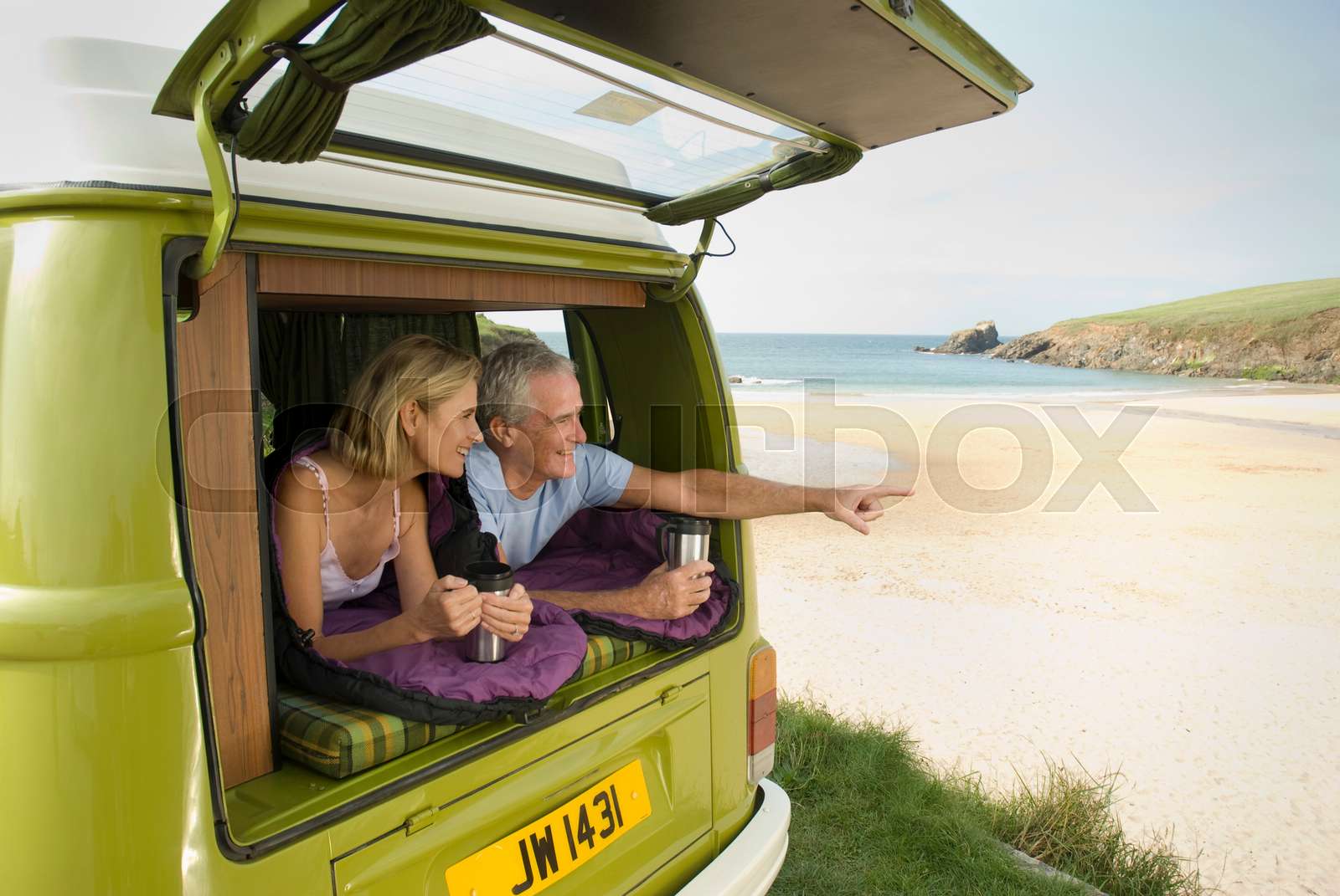 Mature couple lying in camper van | Stock image | Colourbox