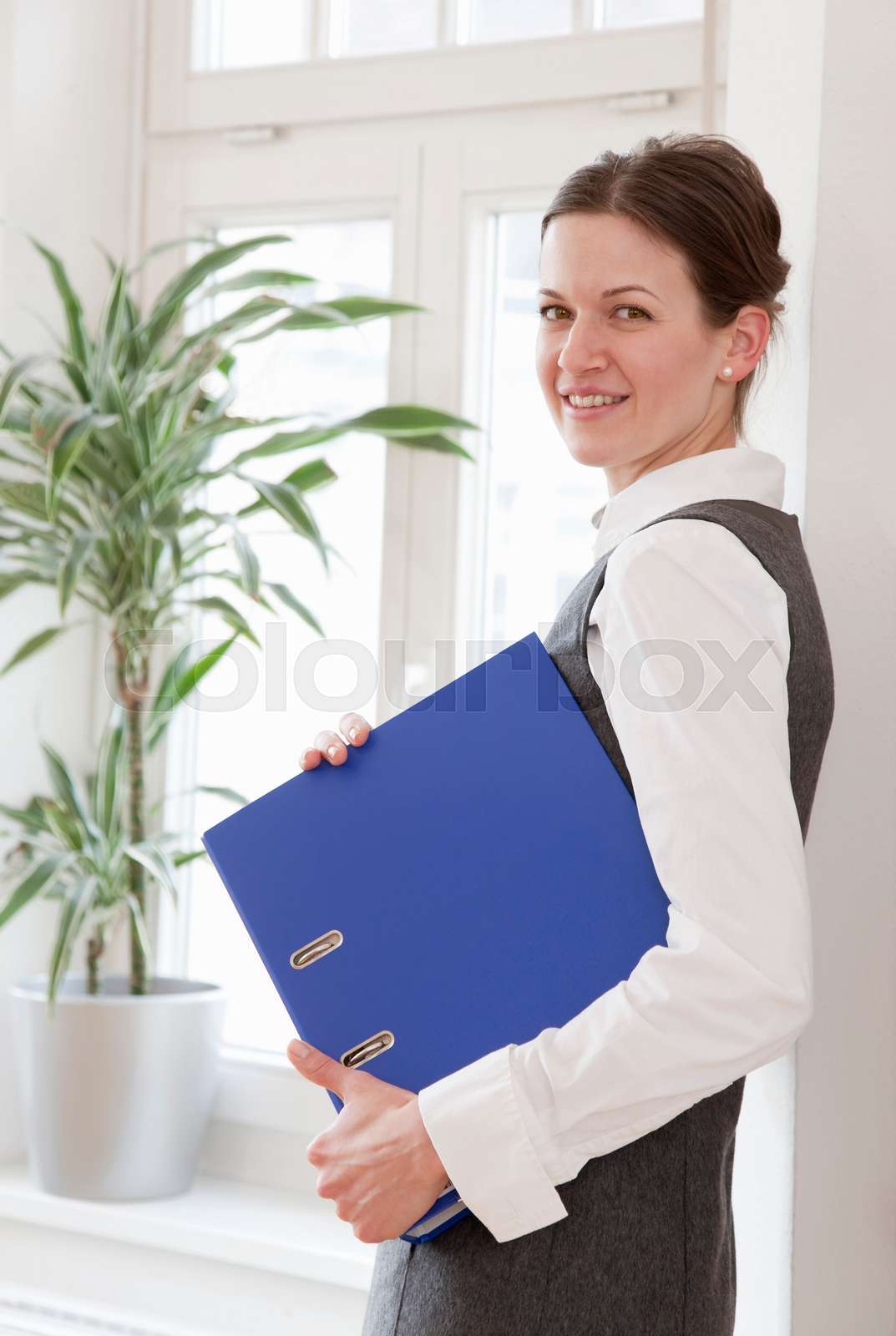 Businesswoman with file folder | Stock image | Colourbox