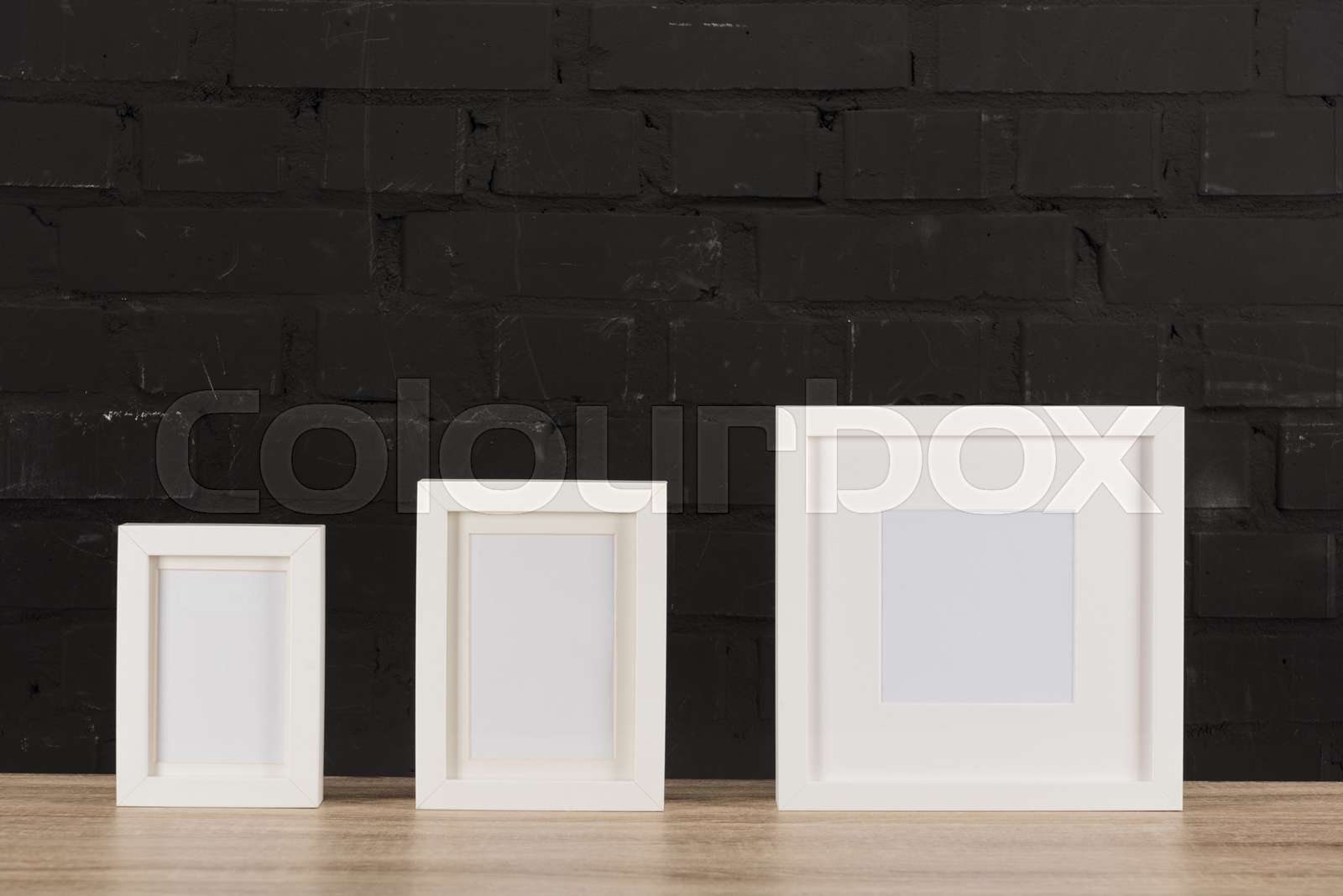 empty photo frames on wooden tabletop | Stock image | Colourbox