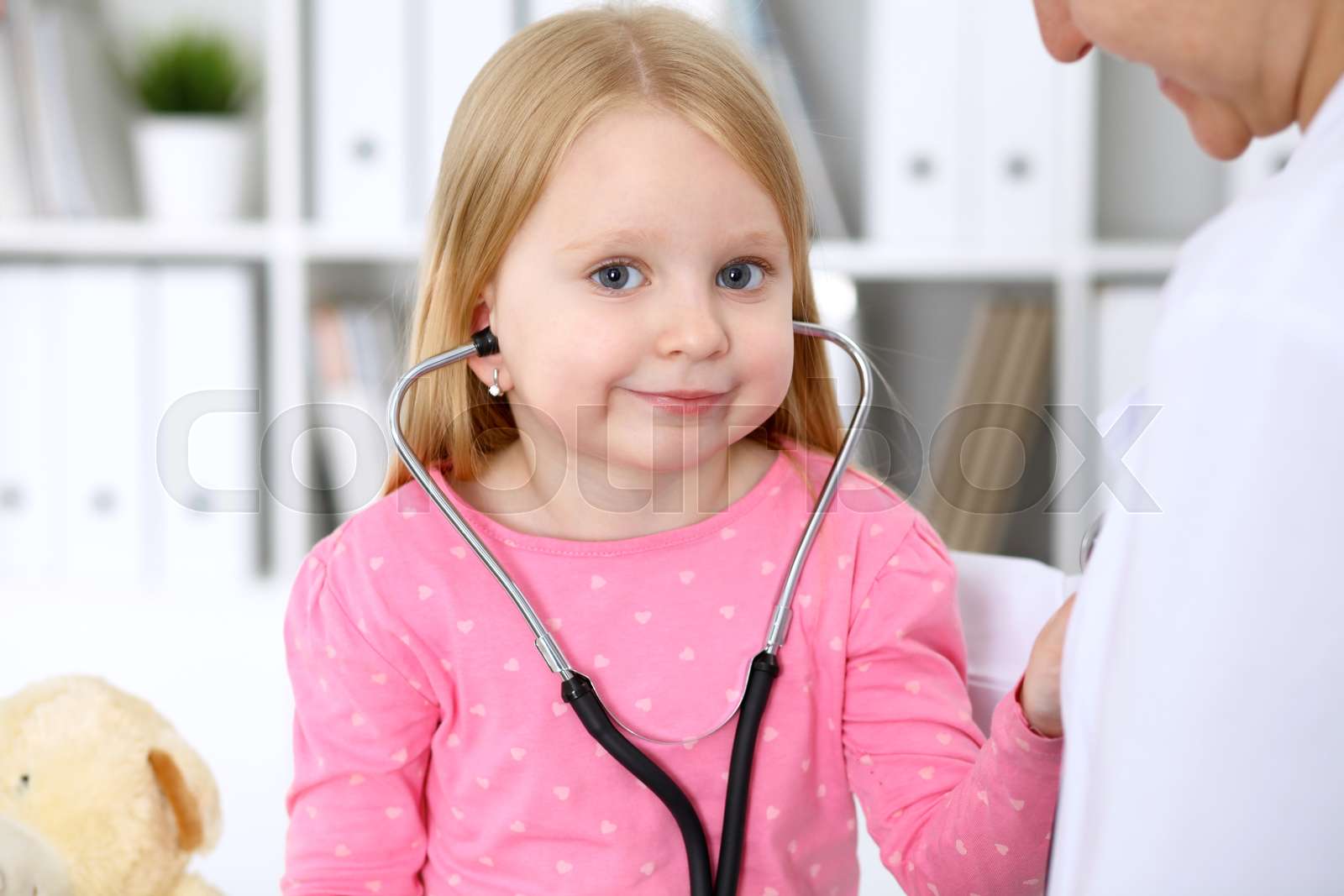 Little girl examining her doctor by stethoscope. Health care, child ...