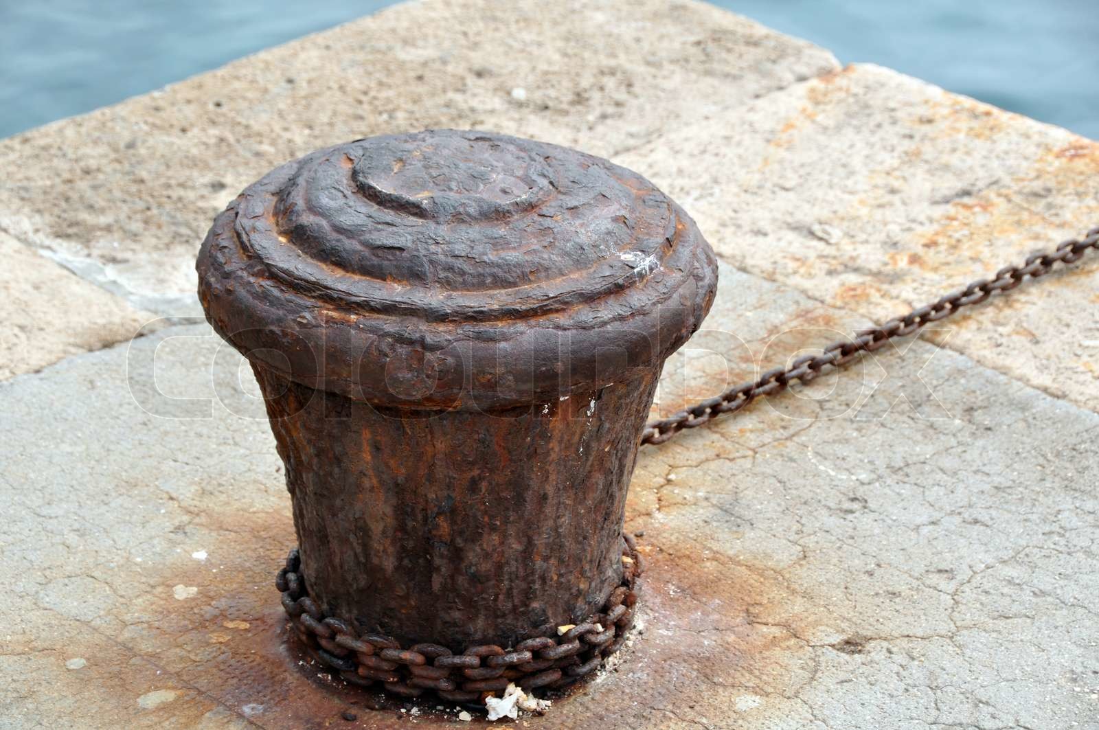 Alte, rostige Poller mit Metall-Kette auf Pier mit Wasser | Stock Bild ...