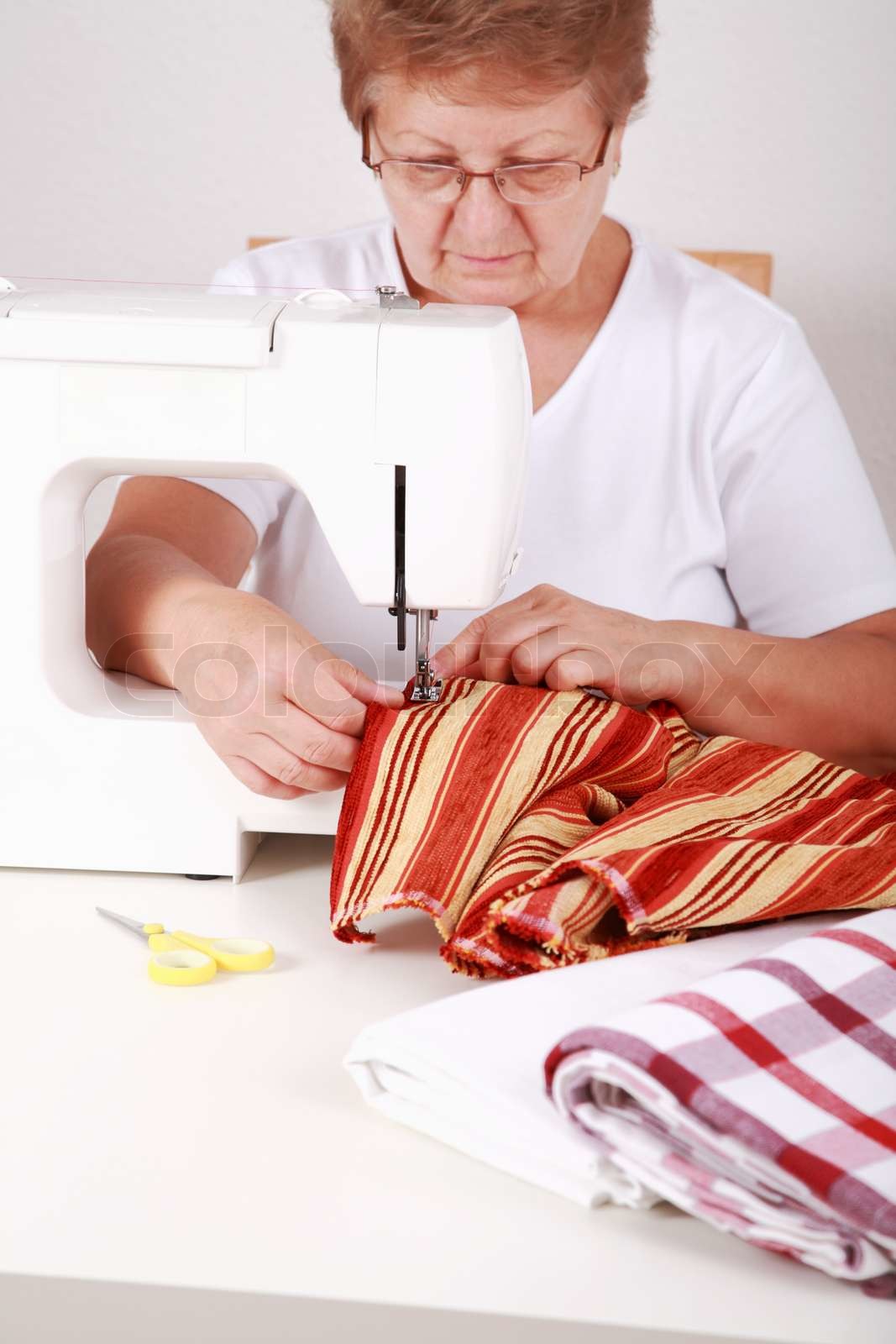Photo of elderly woman sewing | Stock image | Colourbox