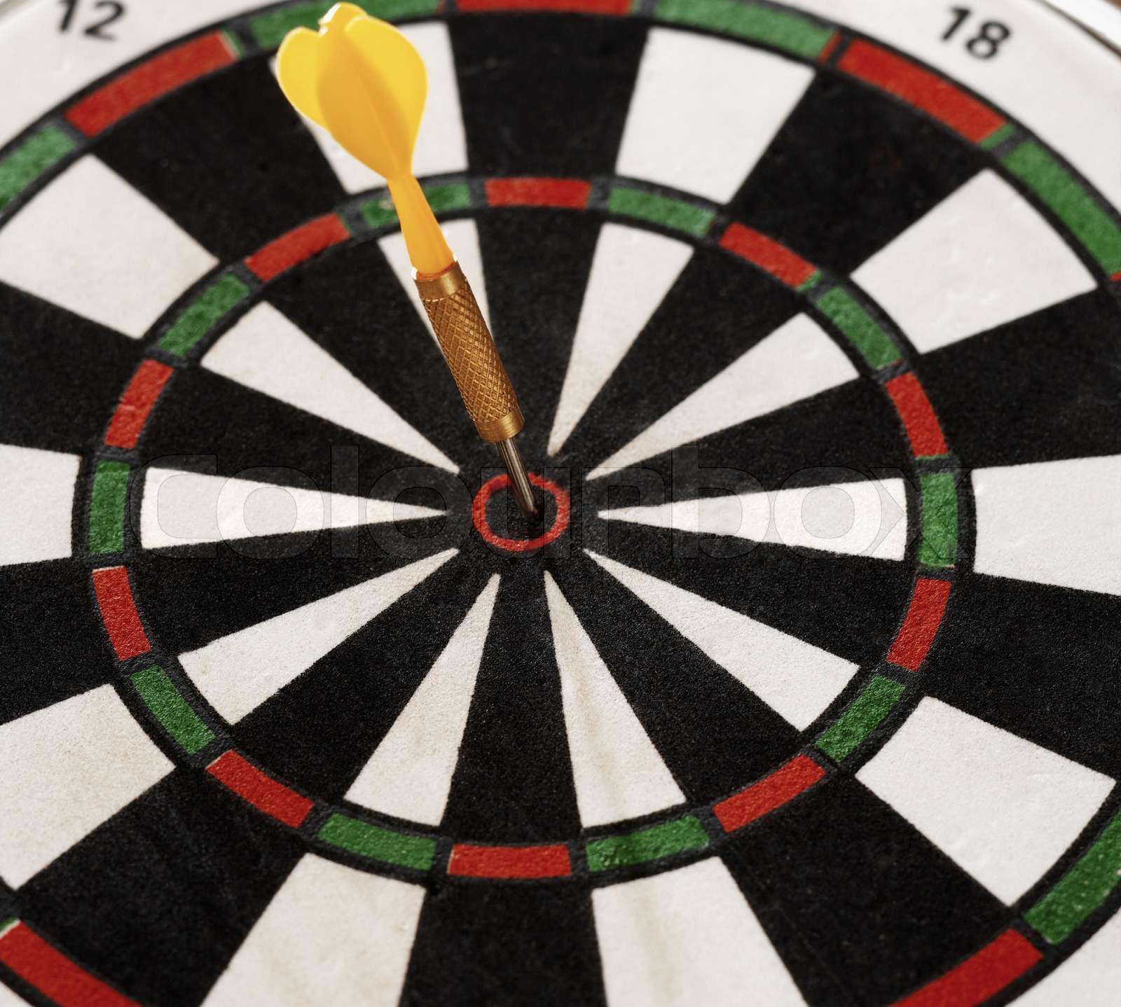 Diagonal view of Dart stuck in a board | Stock image | Colourbox