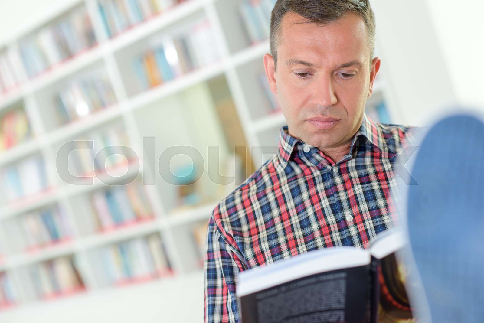 Man reading book in library | Stock image | Colourbox