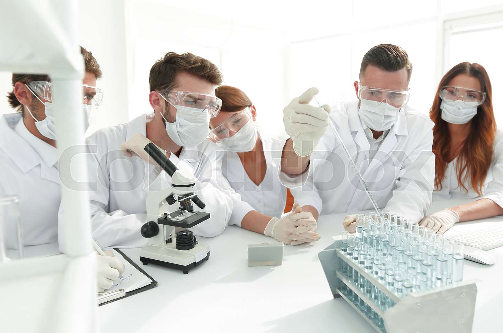 medical doctors are working with test tubes and microscope at the lab ...