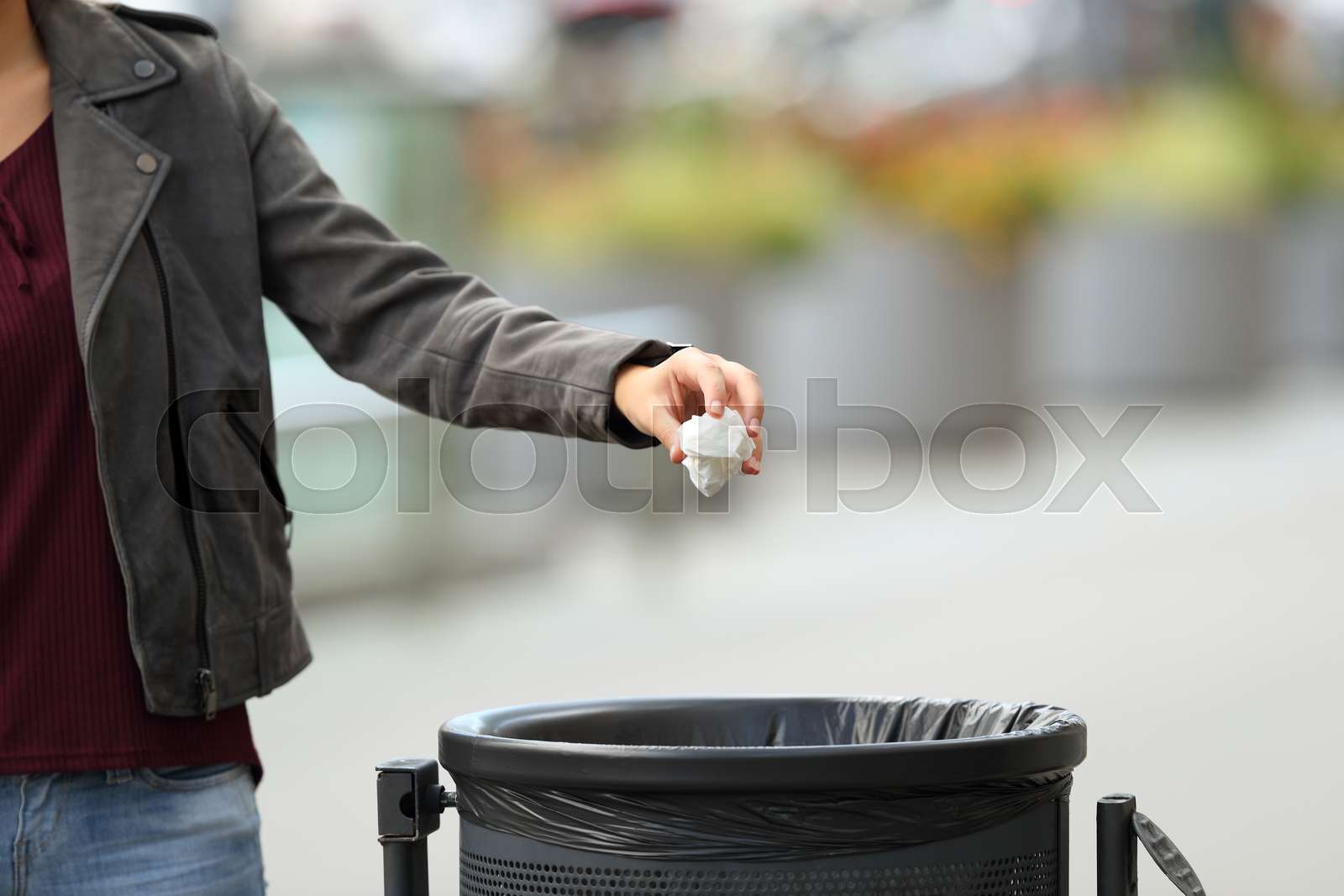 Lady hand throwing garbage to a trash bin | Stock image | Colourbox
