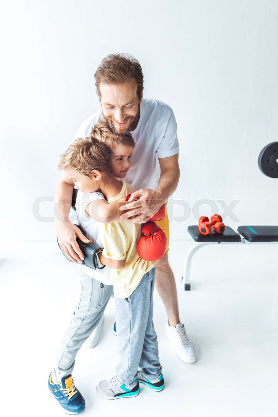 father hugging sons in boxing gloves | Stock image | Colourbox