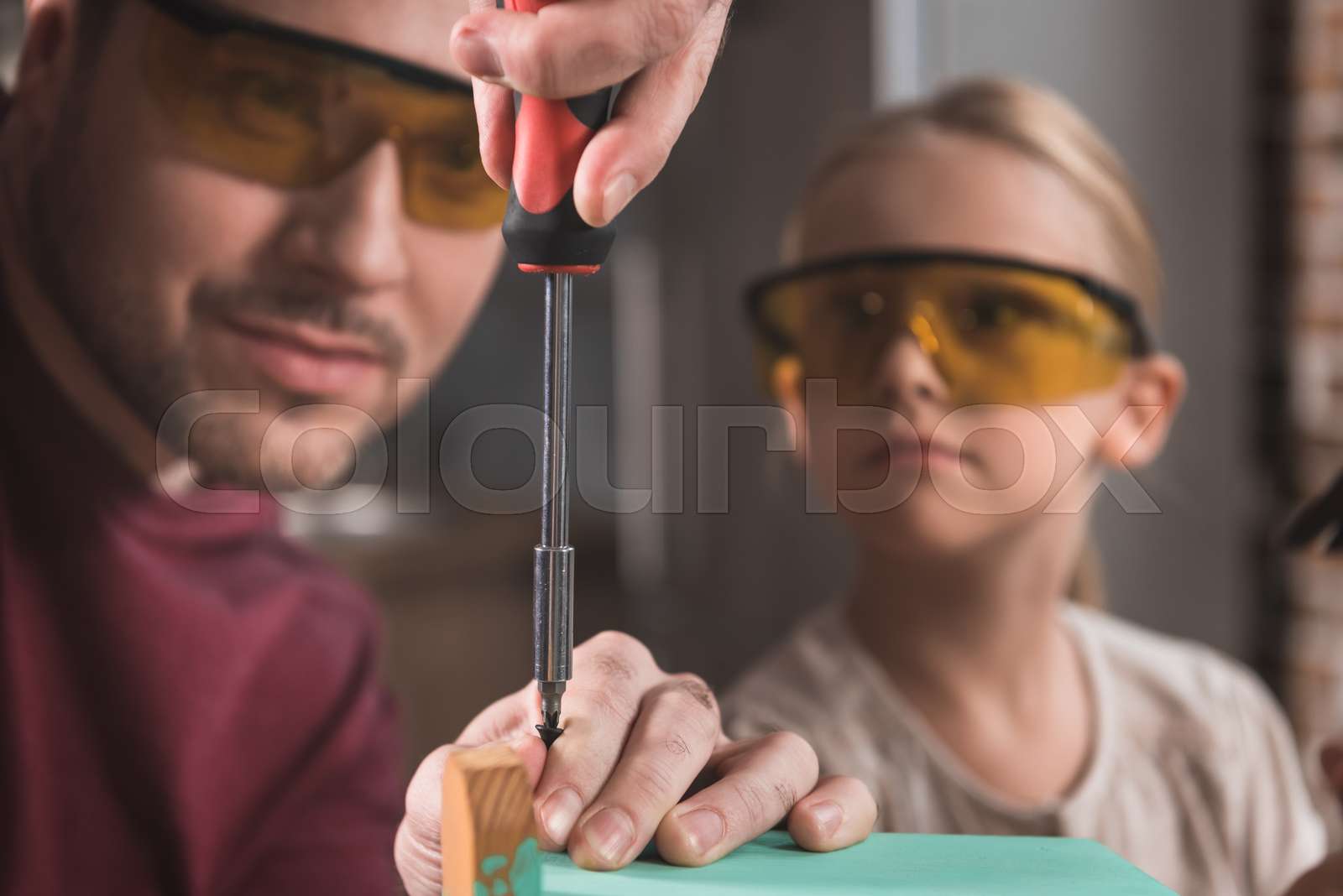 Father showing how use screwdriver | Stock image | Colourbox