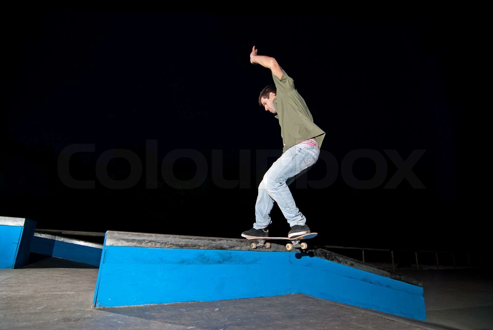 Skateboarder on a slide at night at the local skatepark | Stock image ...