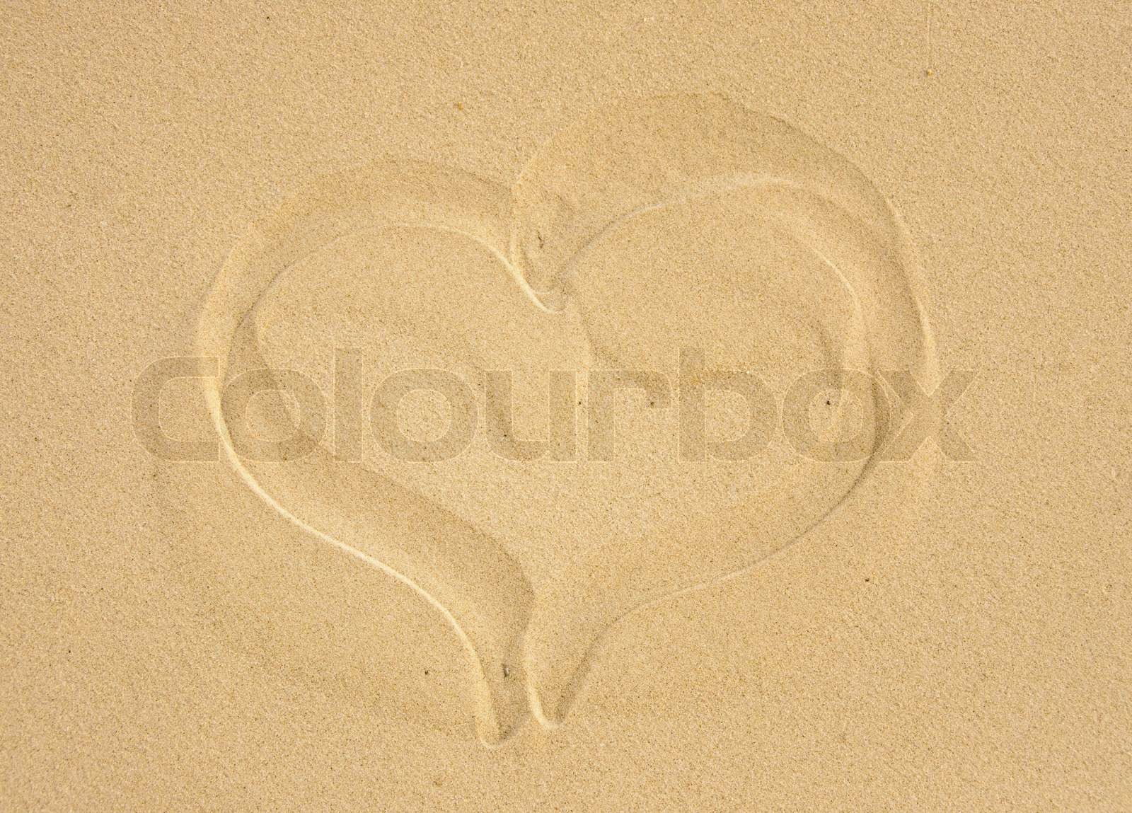 Et hjerte tegnet i sandet på en næb | Stock foto | Colourbox