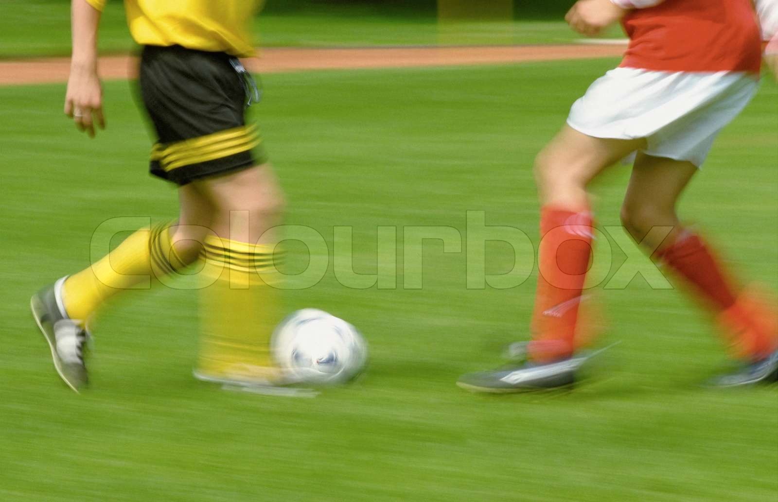 Soccer players running after the ball on green | Stock image | Colourbox