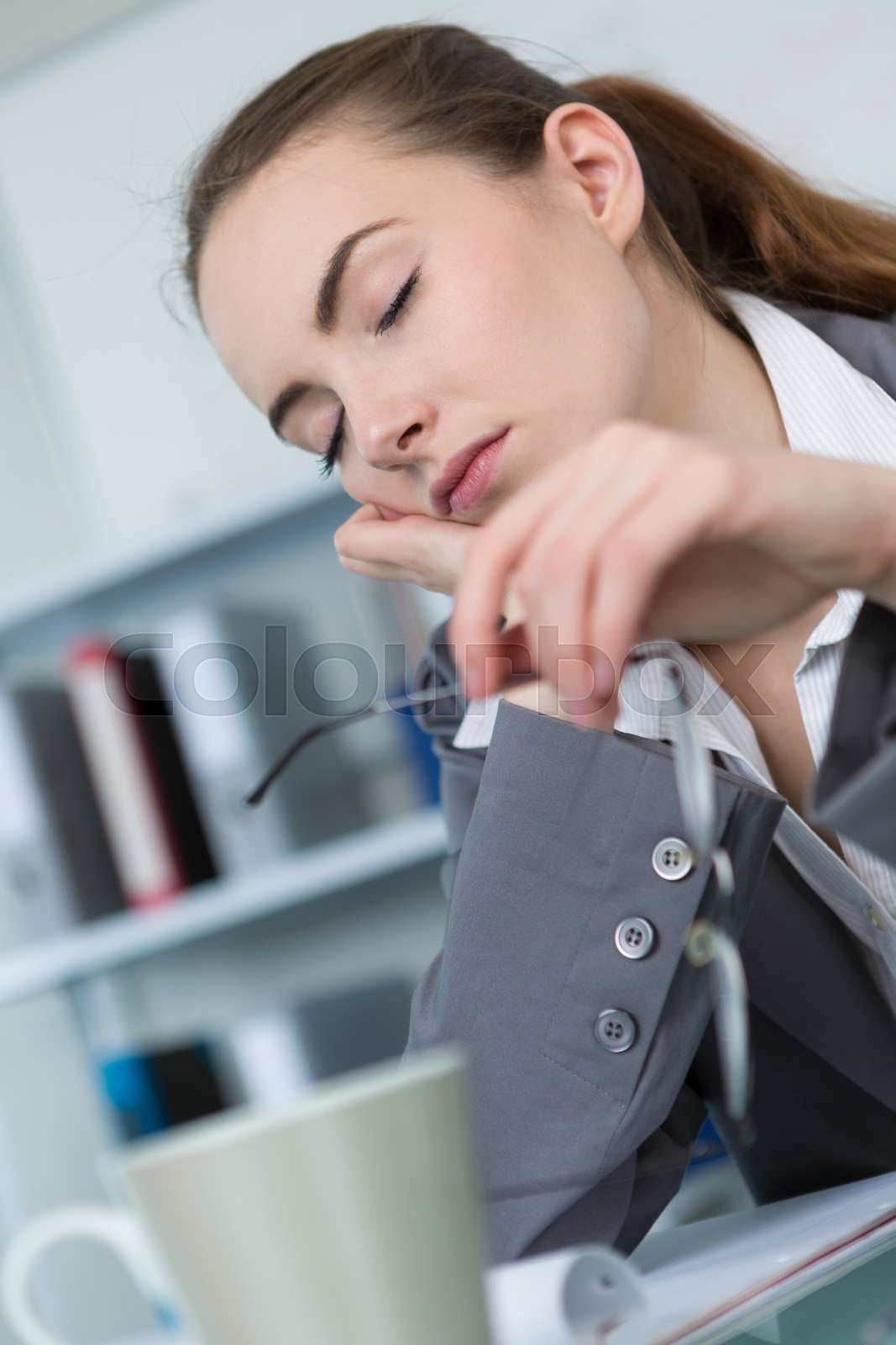 Woman falling asleep at her desk | Stock image | Colourbox