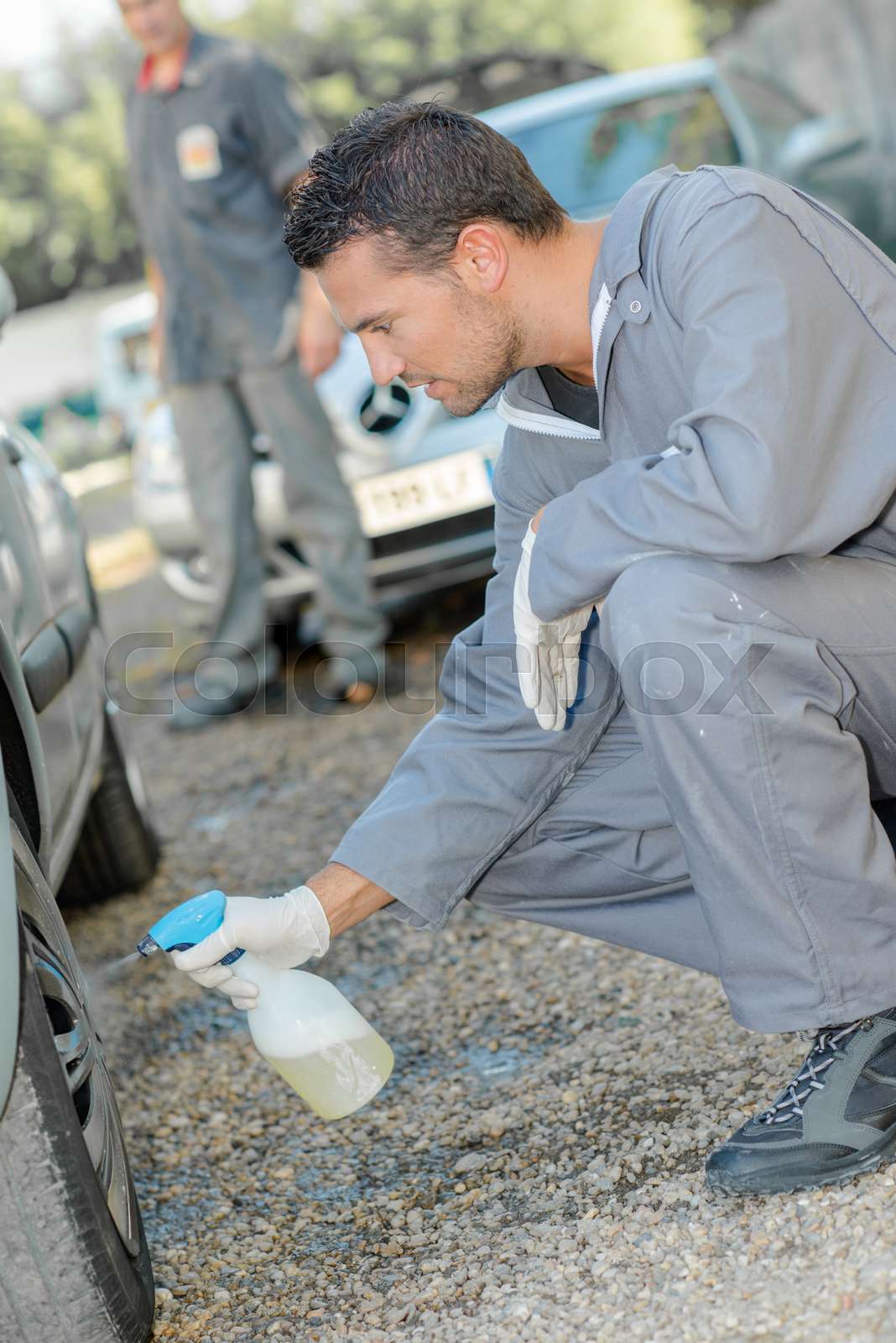 Mechanic washing a customer's car wheels | Stock image | Colourbox