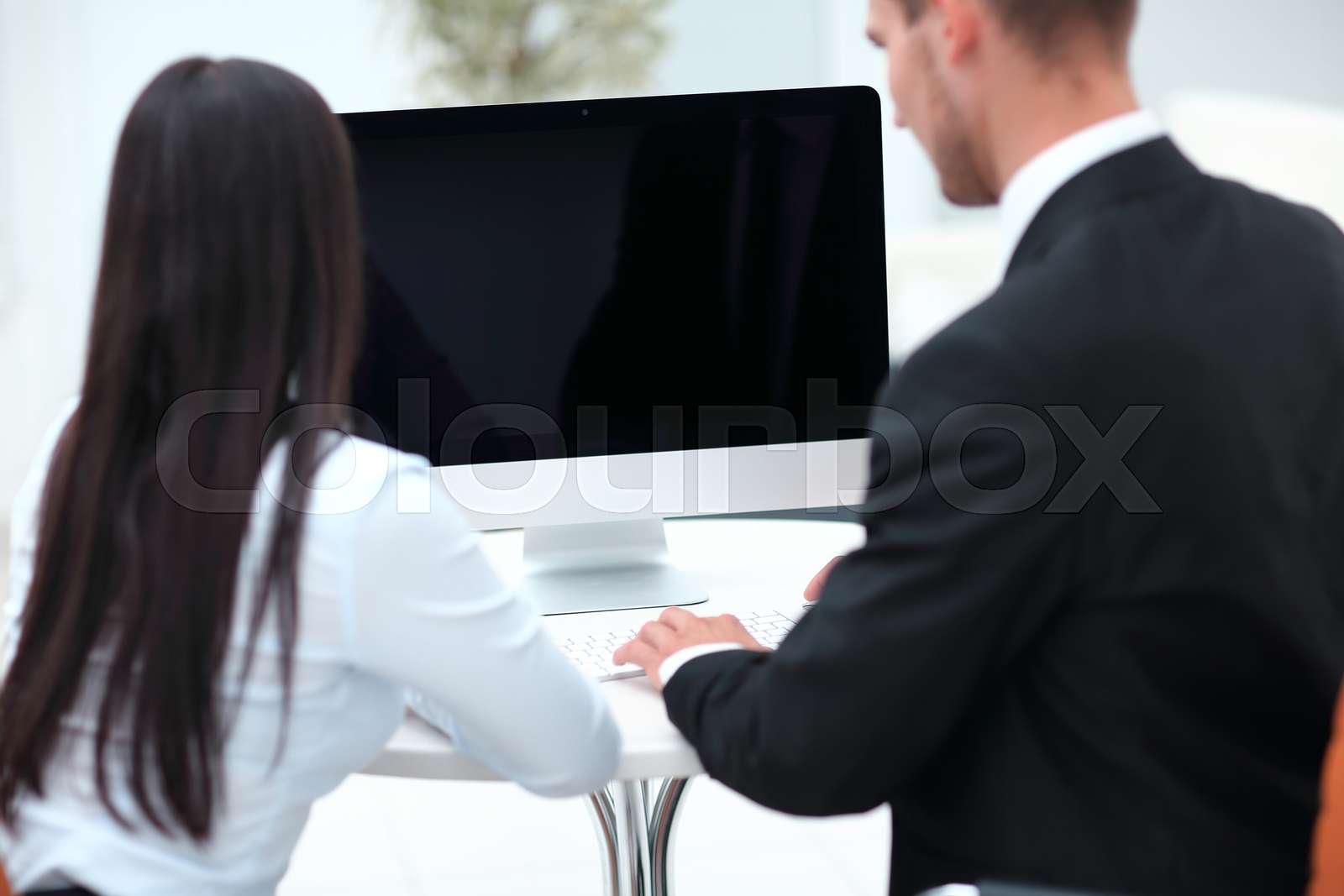 rear view.two successful employee sitting behind a Desk | Stock image ...