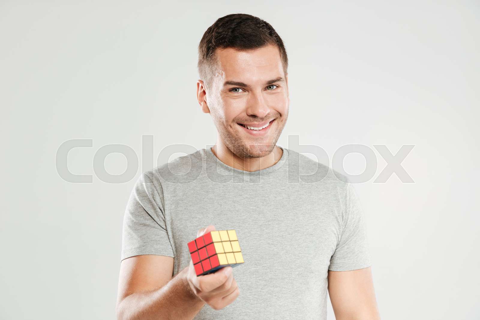 Happy man holding Rubik's cube. | Stock image | Colourbox