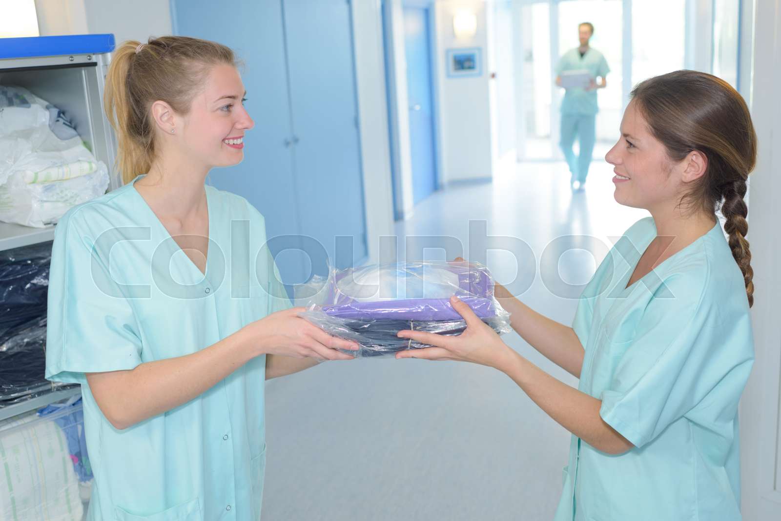 Nurse handing packages to colleague | Stock image | Colourbox
