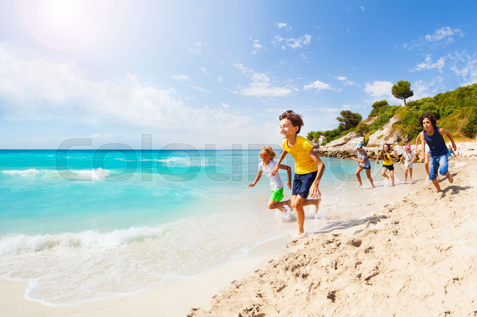 Kids playing catch-up on sandy beach | Stock image | Colourbox