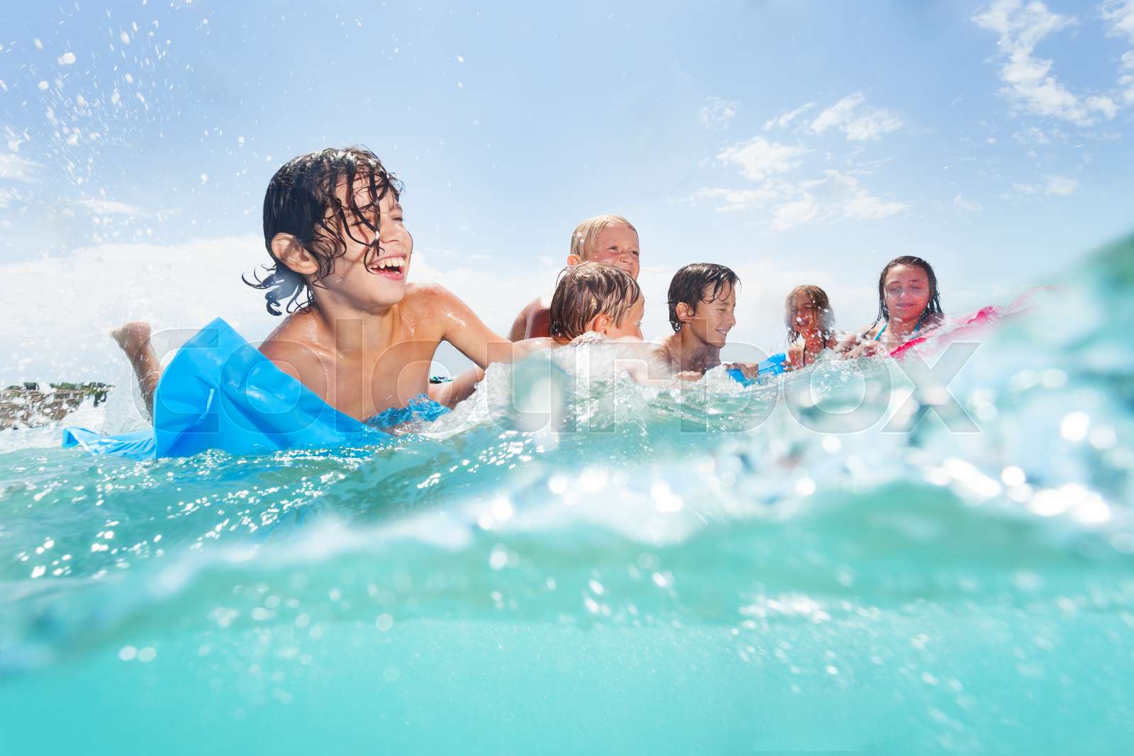 Group of happy kids play in the sea on matrass | Stock image | Colourbox