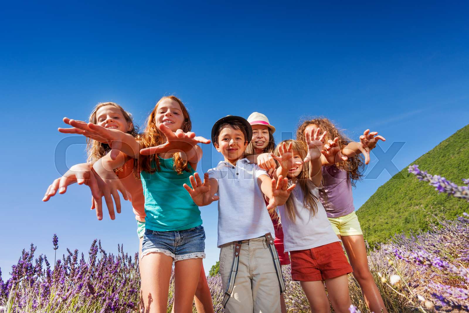 Kids reaching out their hands to camera outdoors | Stock image | Colourbox