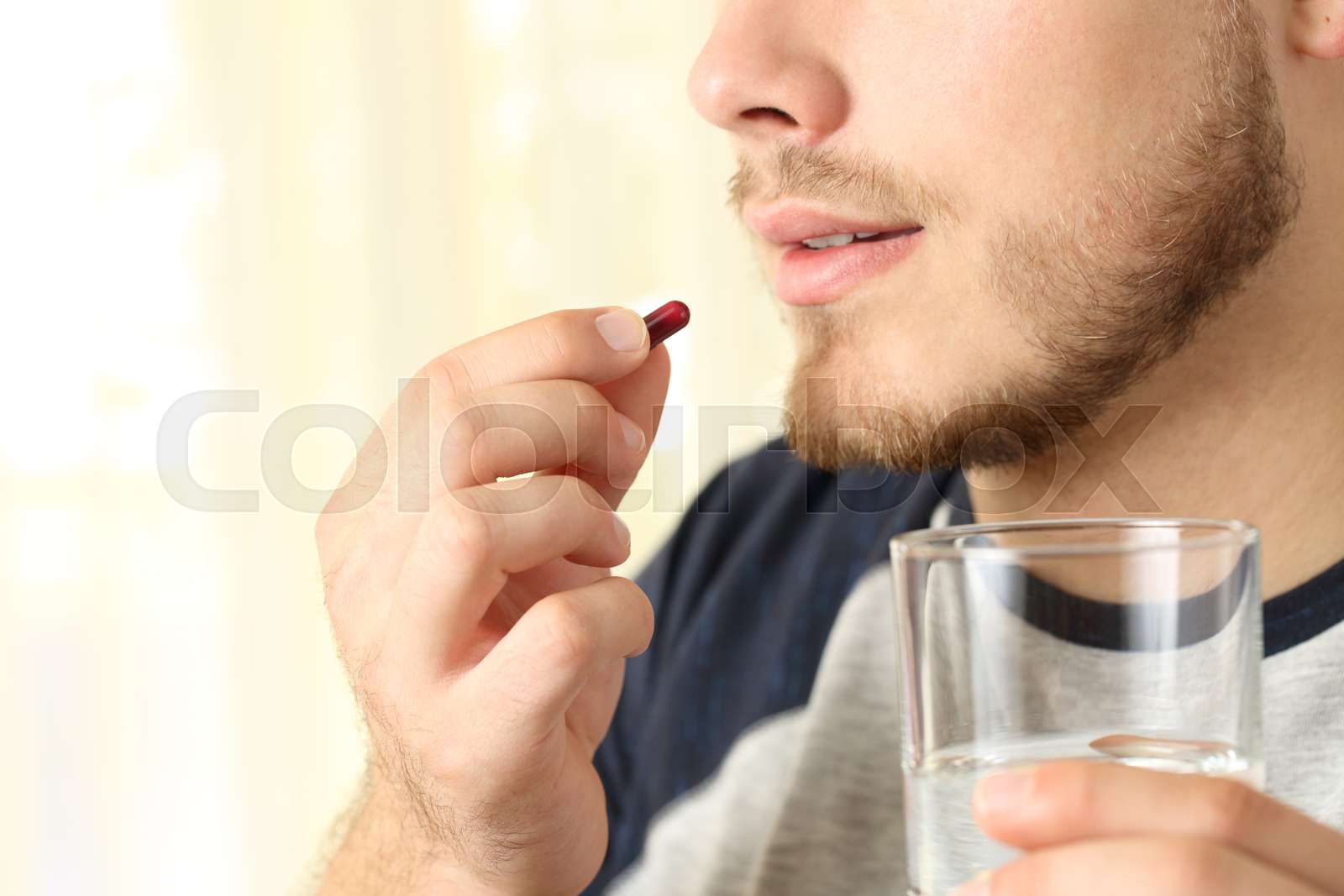 Man ready to swallow a pill | Stock image | Colourbox