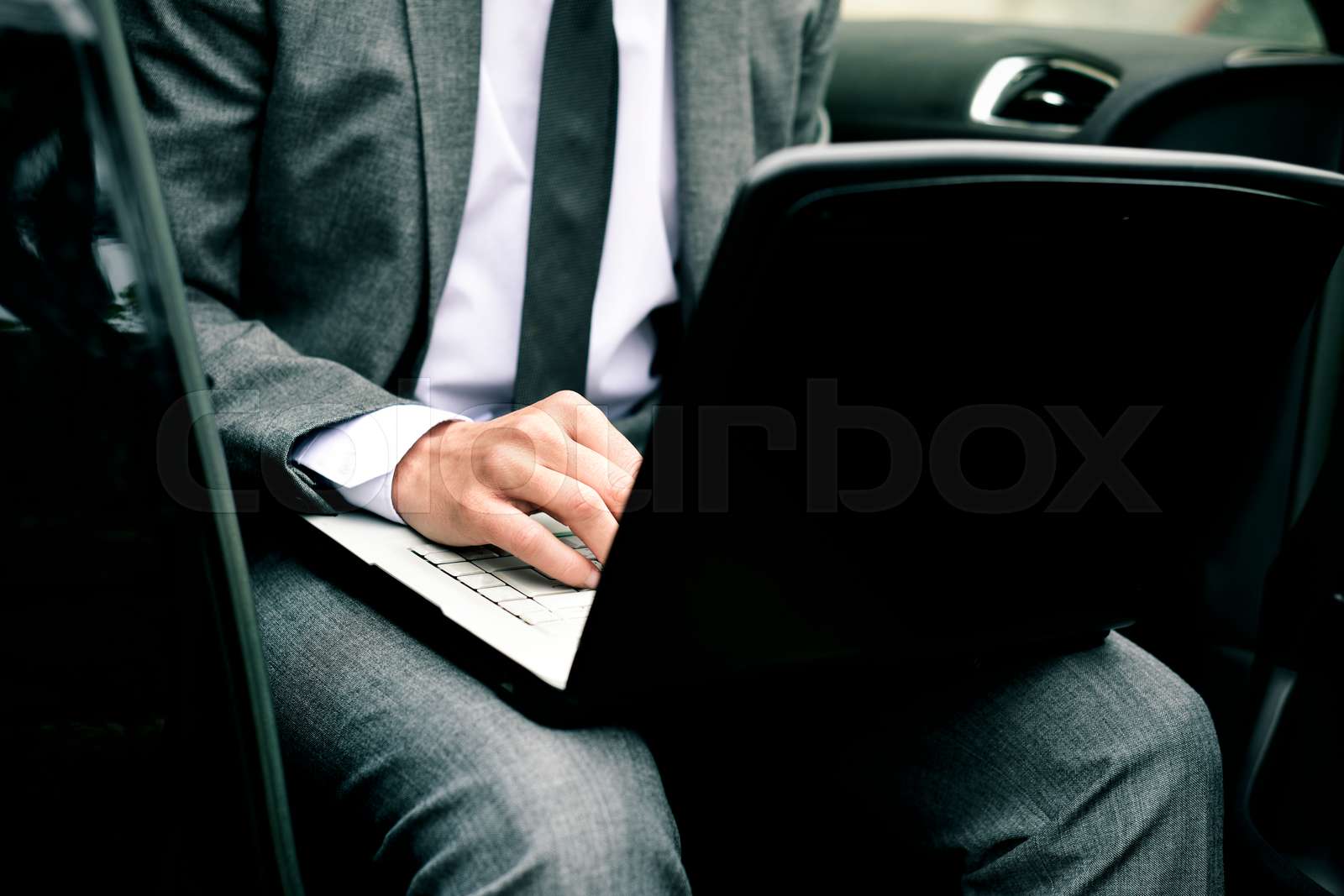 businessman using a laptop in a car | Stock image | Colourbox
