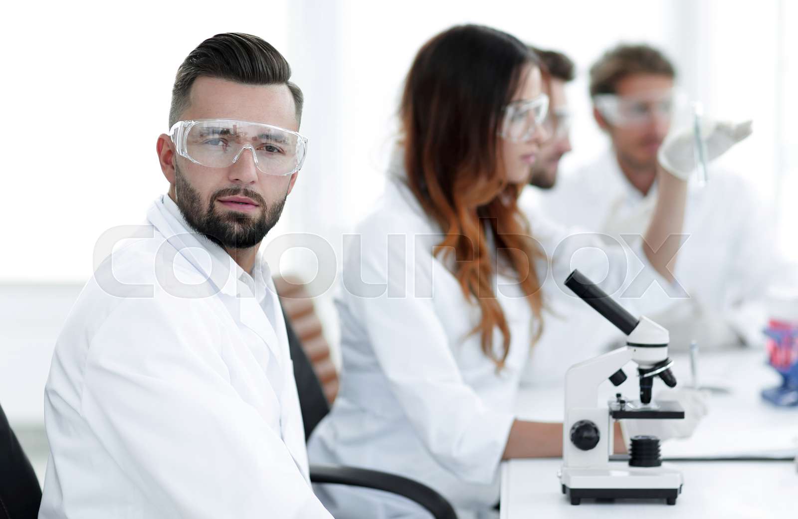 microbiologist and his colleagues are sitting in a modern laboratory ...