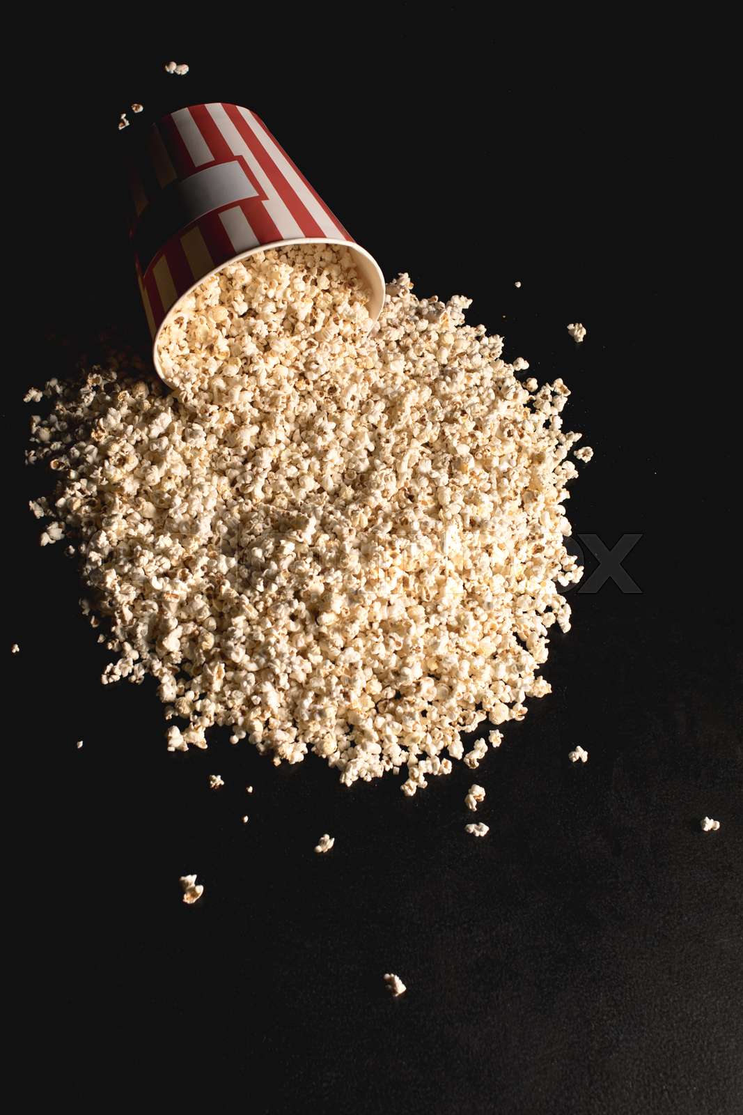 popcorn spilled from cardboard bucket | Stock image | Colourbox