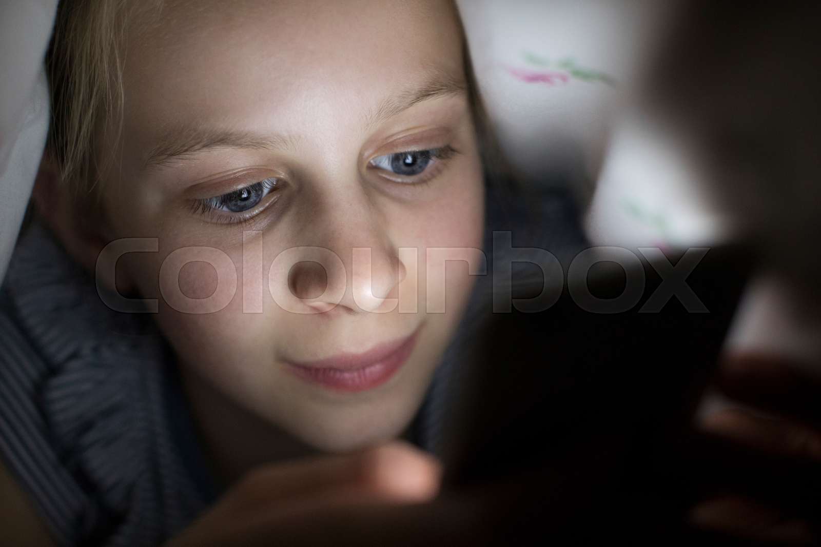 Girl Using Mobile Phone Hiding Under Duvet In Bed At Night | Stock ...